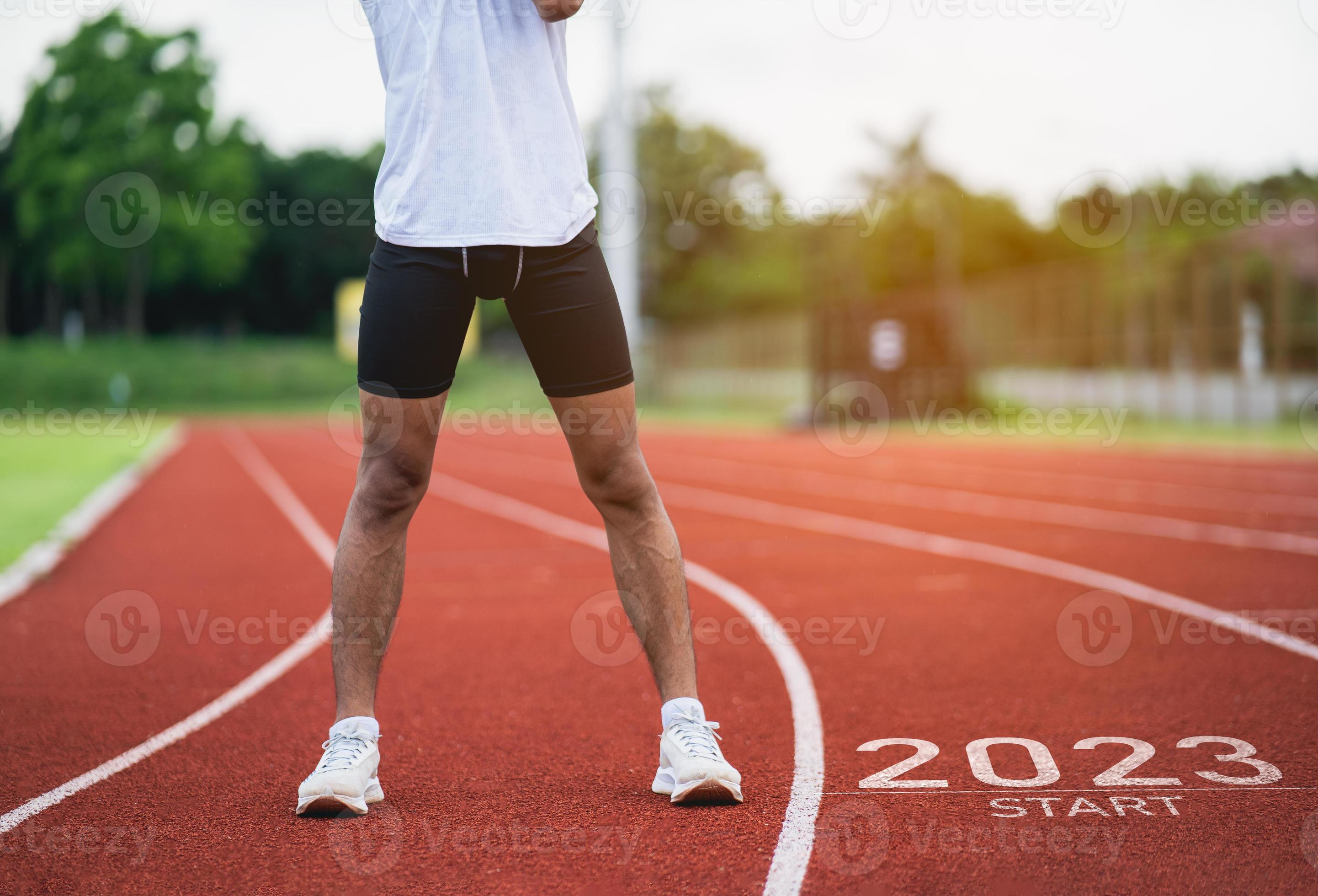 Sport man runner stretching at running track start into the new year ... Sport man runner stretching at running track start into the new year ...