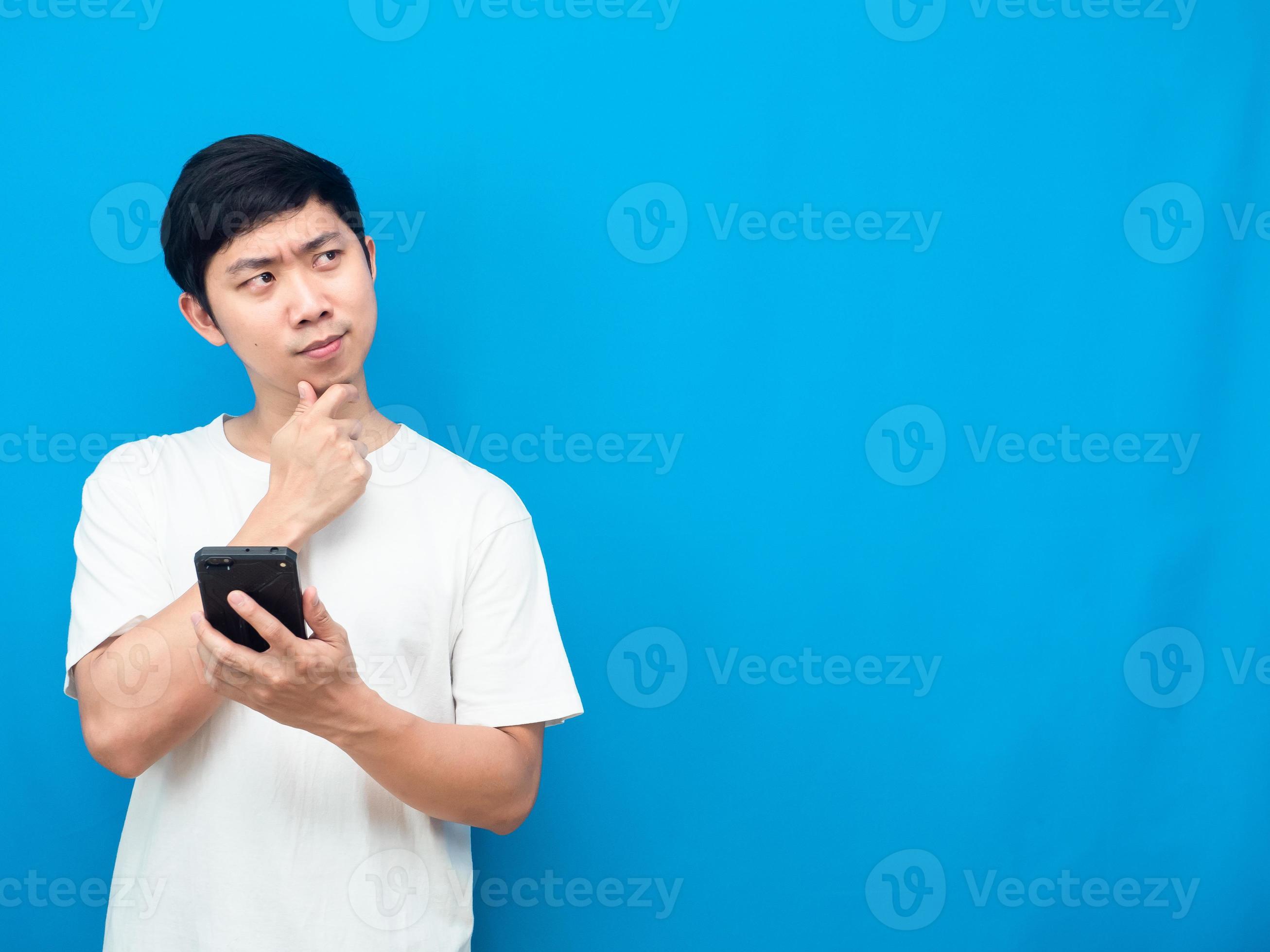 Young Man White Shirt Holding Mobile Phone Gesture Thinking And Looking