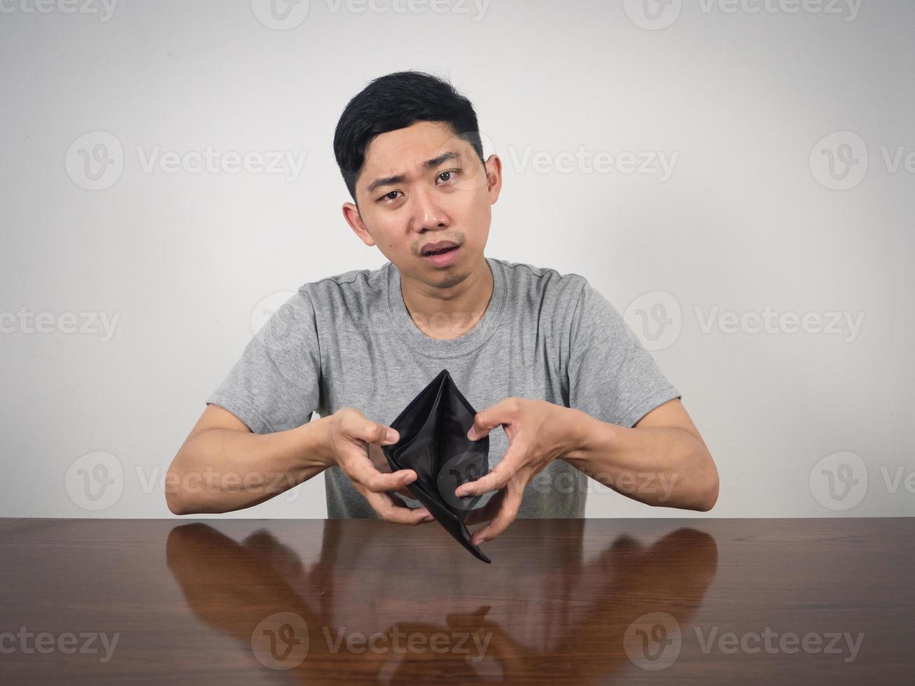 Poor man strain with no money show empty wallet at table 16790155 Stock Photo at Vecteezy