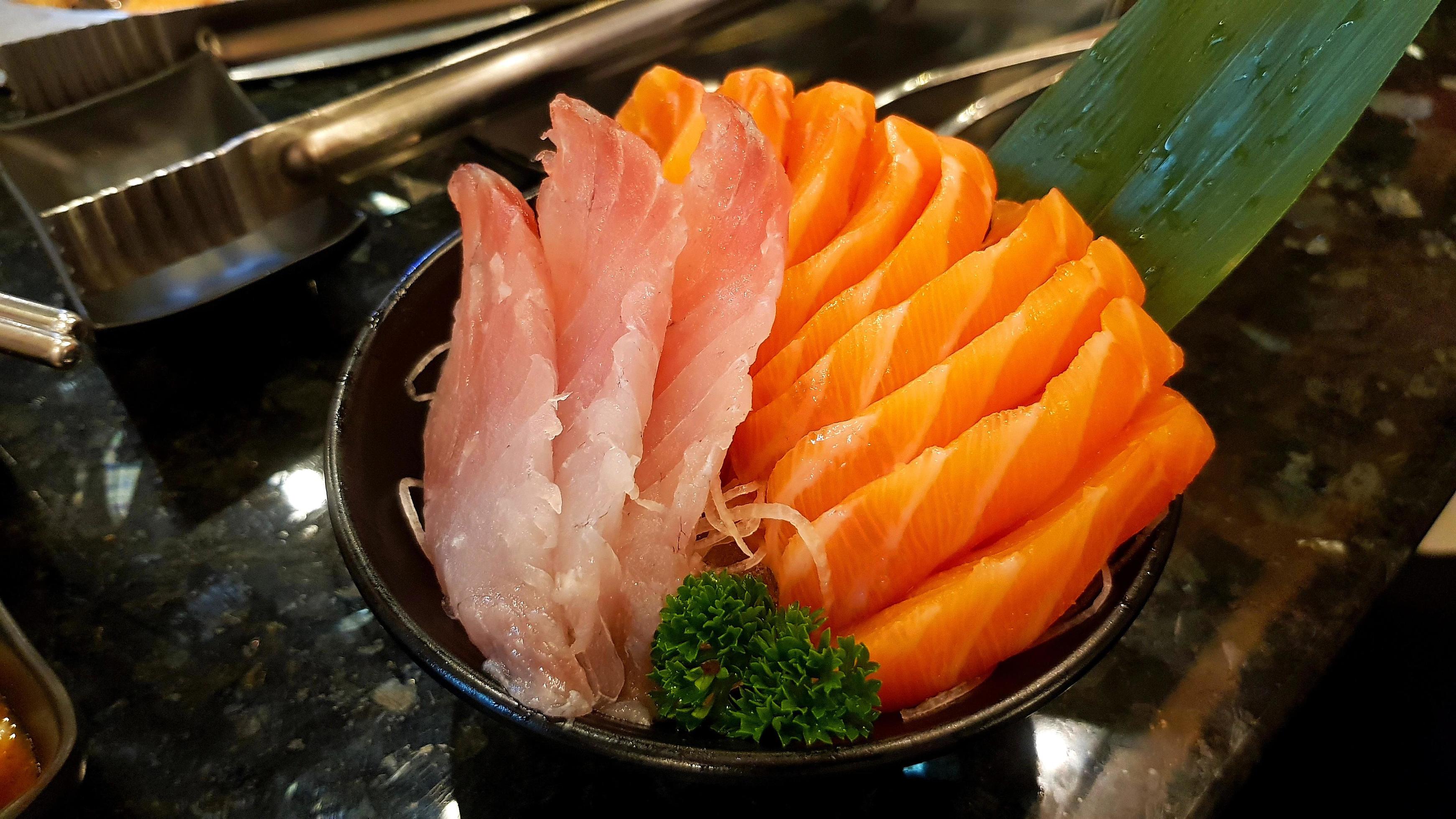 Fresh salmon and tuna sliced on black bowl at Japanese restaurant. Freshness sashimi and fish ...