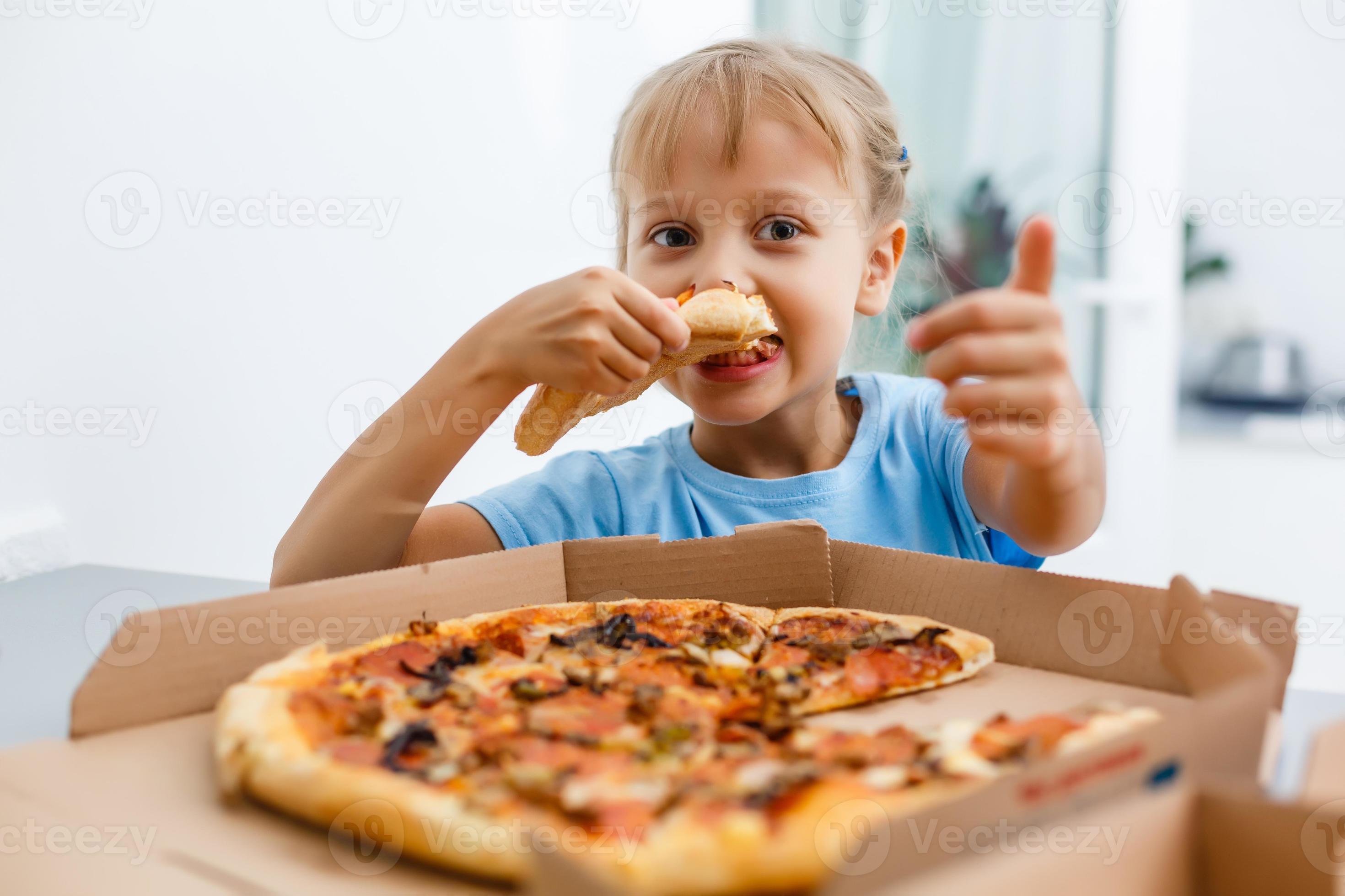 niña comiendo pizza en casa 16849279 Foto de stock en Vecteezy