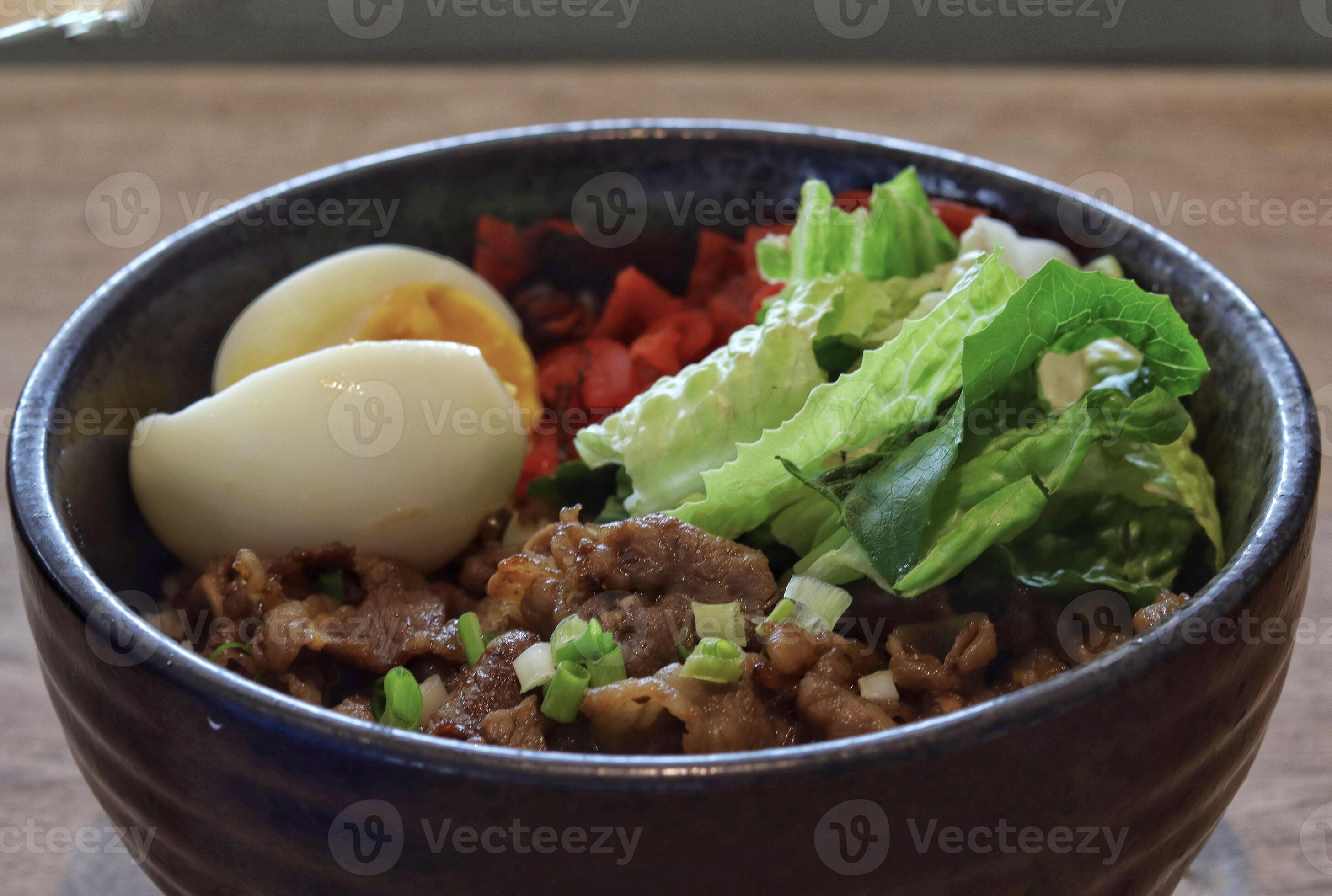 Beef Donburi Japanese rice, topped with yakiniku beef and egg serve in the table. 17008647 Stock ...