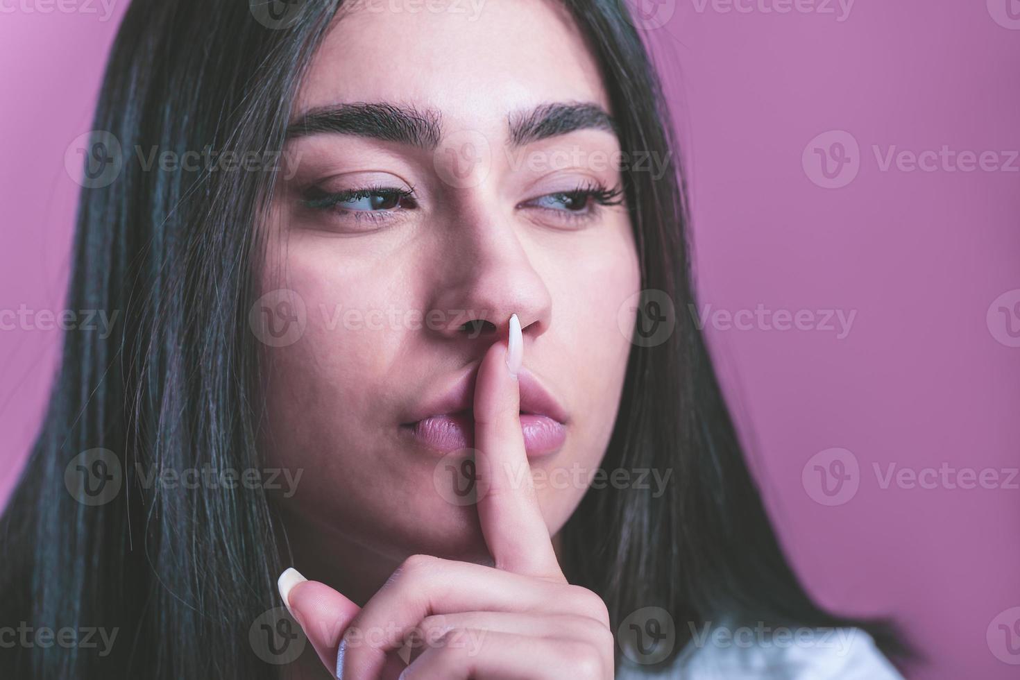 Photo of the creative expression of the silent woman. Brunette woman doing shhh sign 17011421 ...