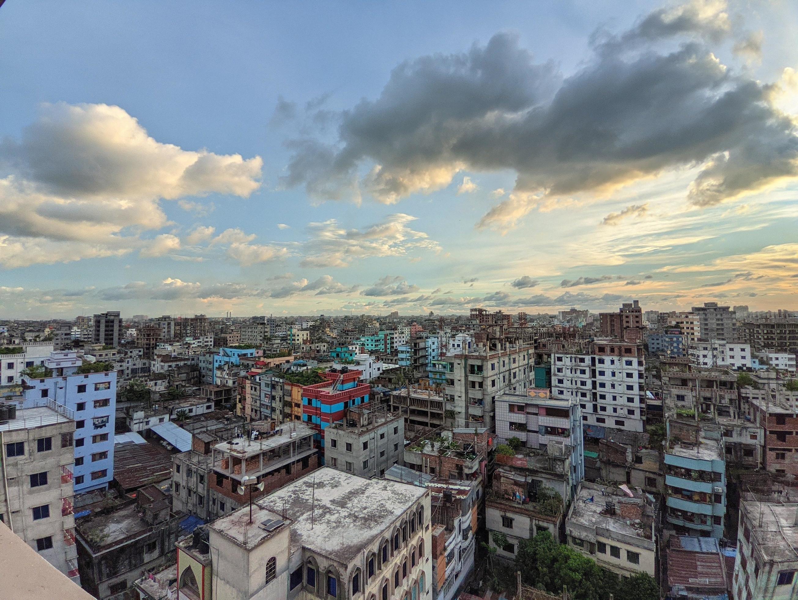 City view from the building roof in Dhaka, Bangladesh. Beautiful Sunset, blue cloudy sky ...