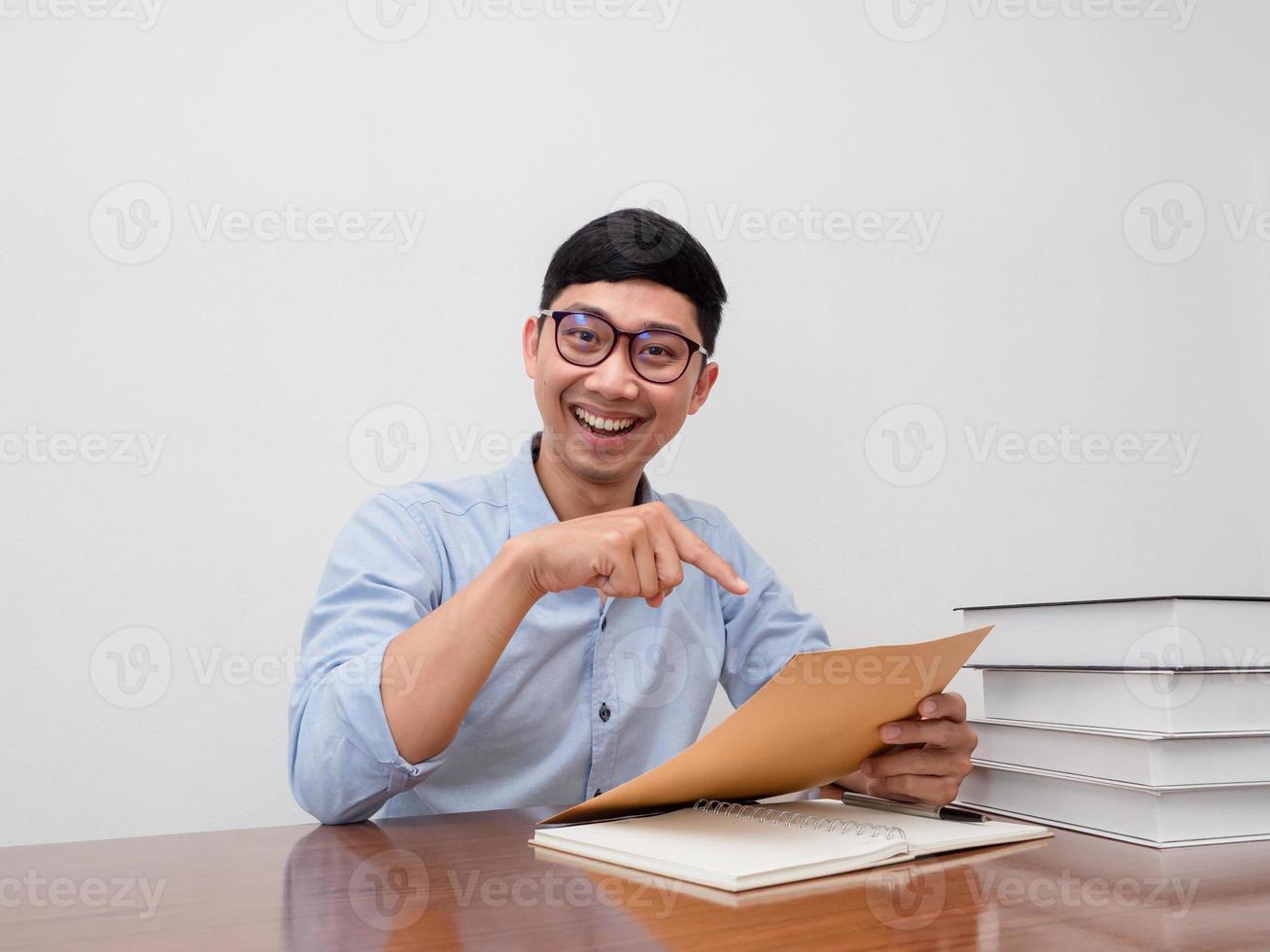 Cheerful asian businessman smile and point finger at the document in ...