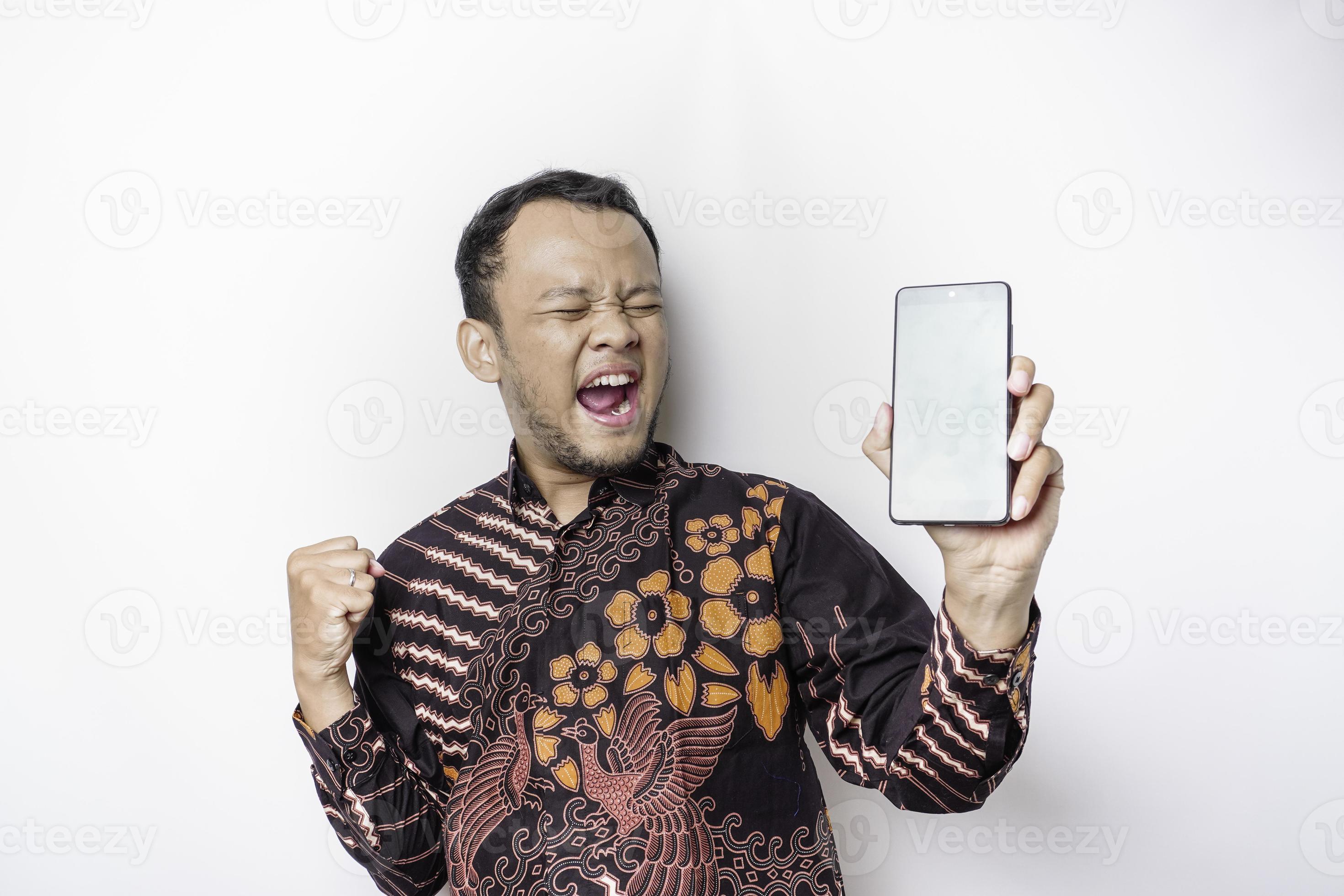 A happy young Asian man wearing batik shirt showing successful ...