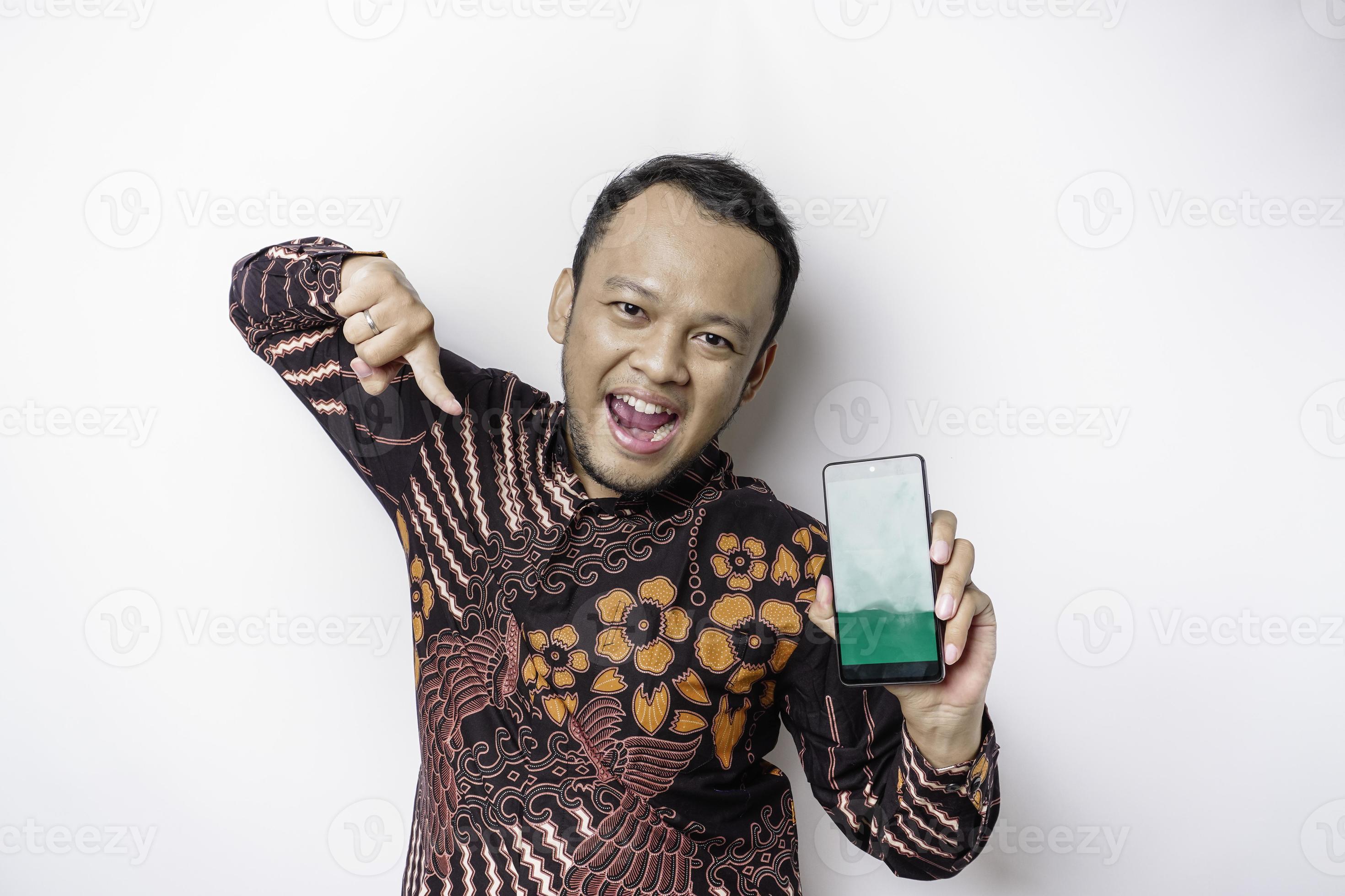 A portrait of a smiling Asian man wearing a batik shirt and showing ...