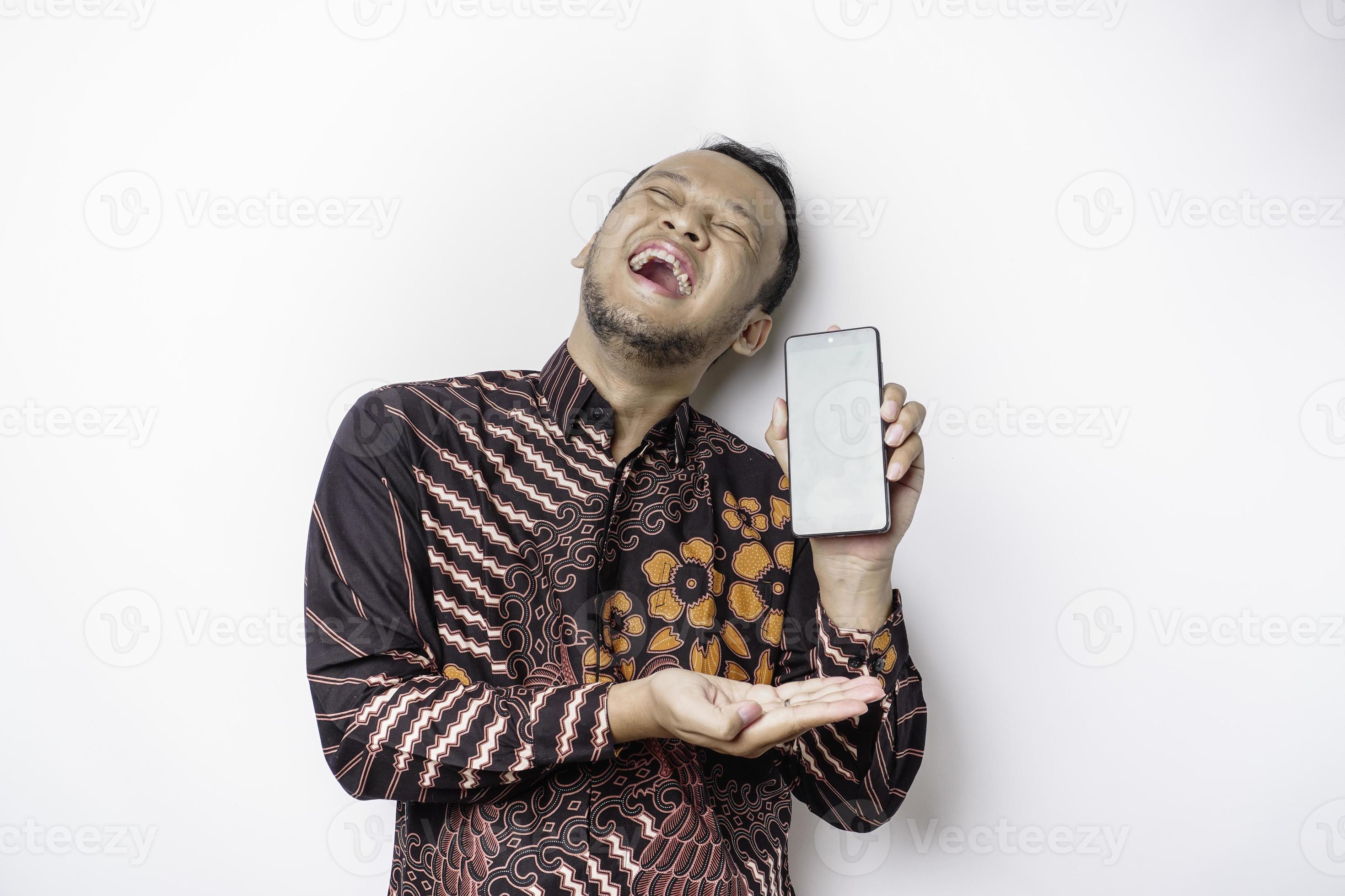 A portrait of a smiling Asian man wearing a batik shirt and showing ...