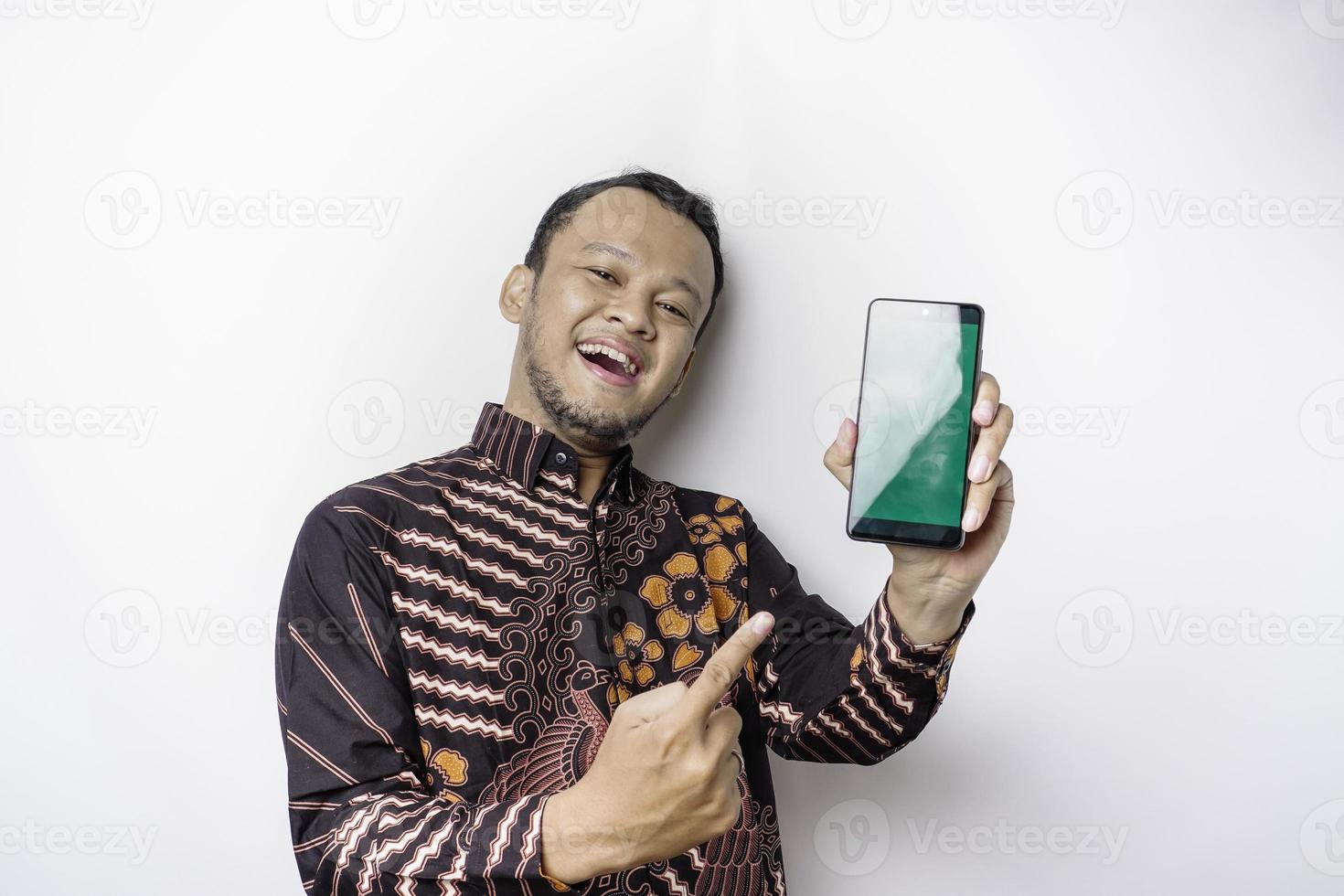 A portrait of a smiling Asian man wearing a batik shirt and showing ...