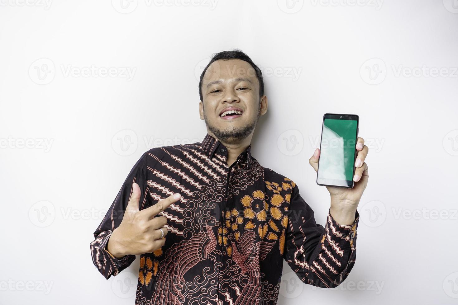 A portrait of a smiling Asian man wearing a batik shirt and showing ...