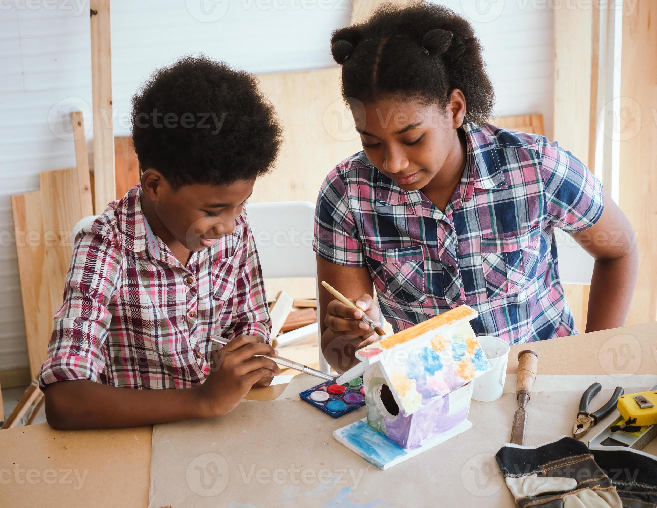 Two African American brothers and sisters help each other make wooden ... Two African American brothers and sisters help each other make wooden ...