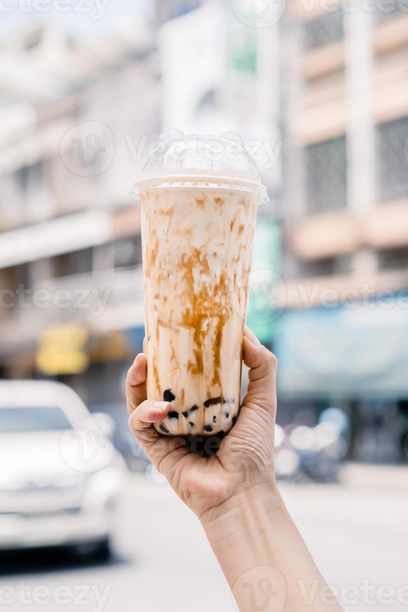 bubble ball ice Milk Tea in the hand with blur Asia building background. 17150592 Stock Photo at ...
