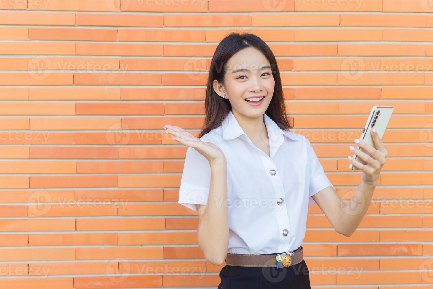 el retrato de una hermosa estudiante asiática tailandesa en uniforme está de pie sonriendo feliz ...