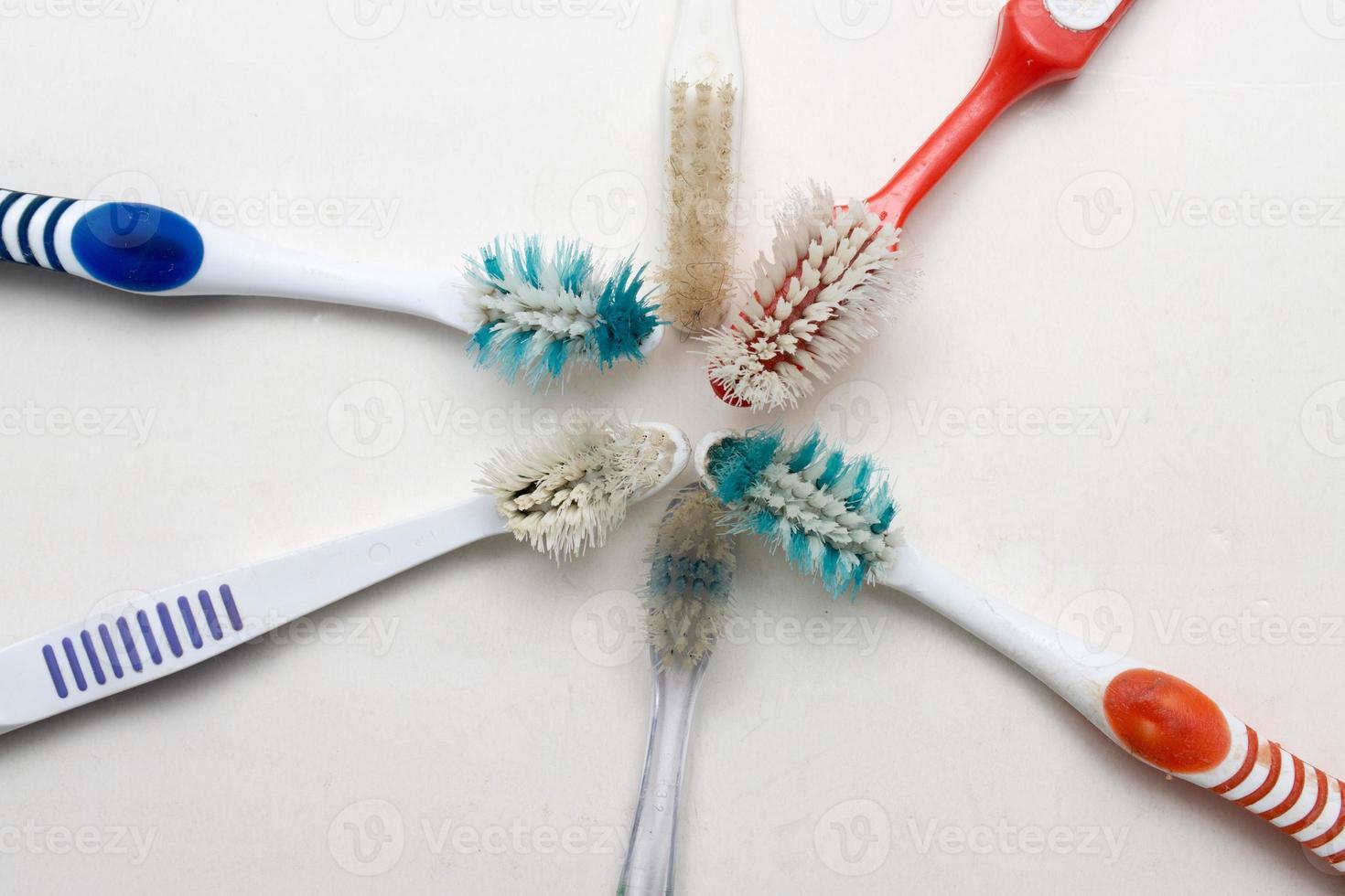 A bunch of old worn out toothbrushes with bent bristles on a white ...
