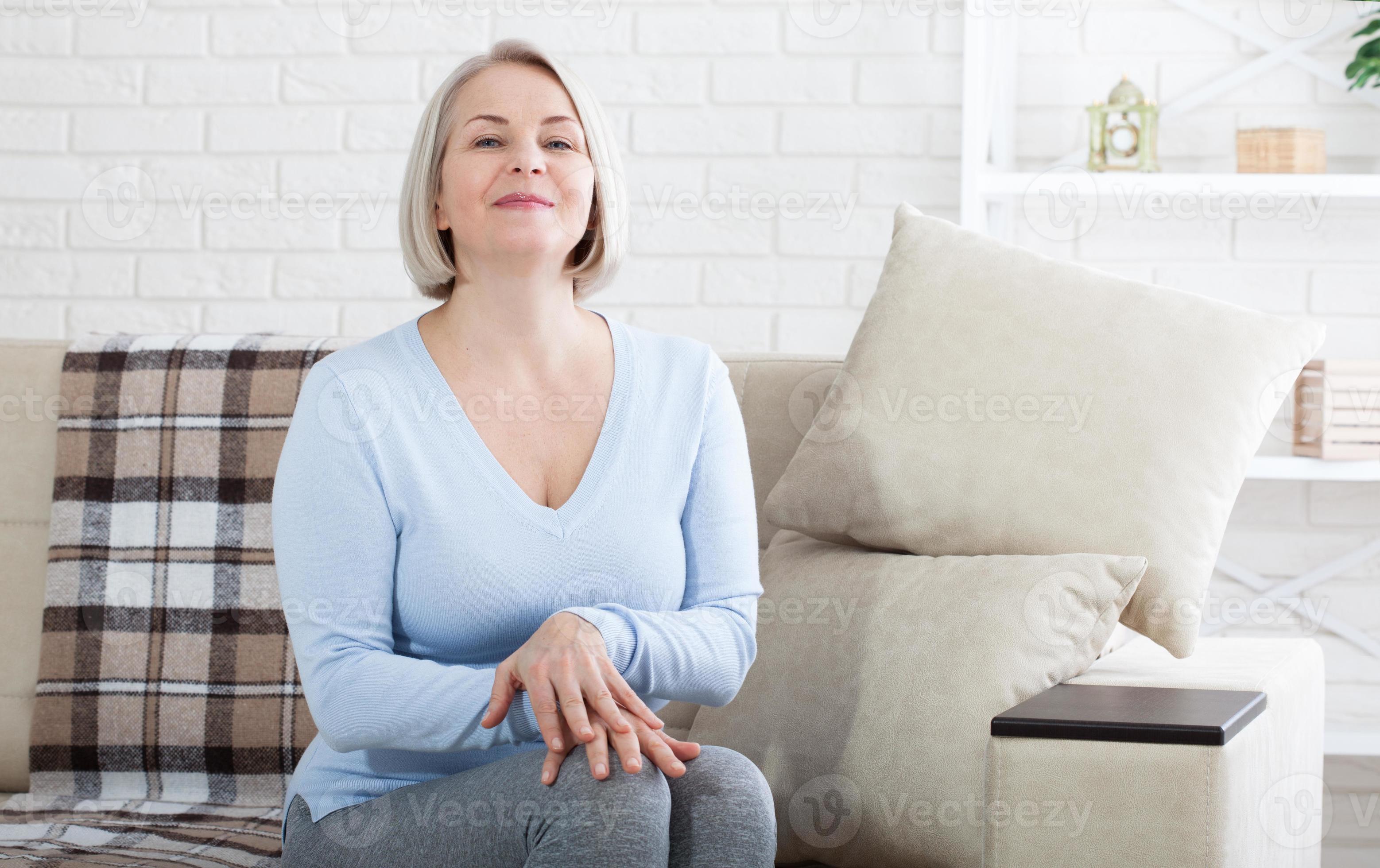 Smiling mature woman sitting on her sofa 17400612 Stock Photo at Vecteezy Smiling mature woman sitting on her sofa 17400612 Stock Photo at Vecteezy