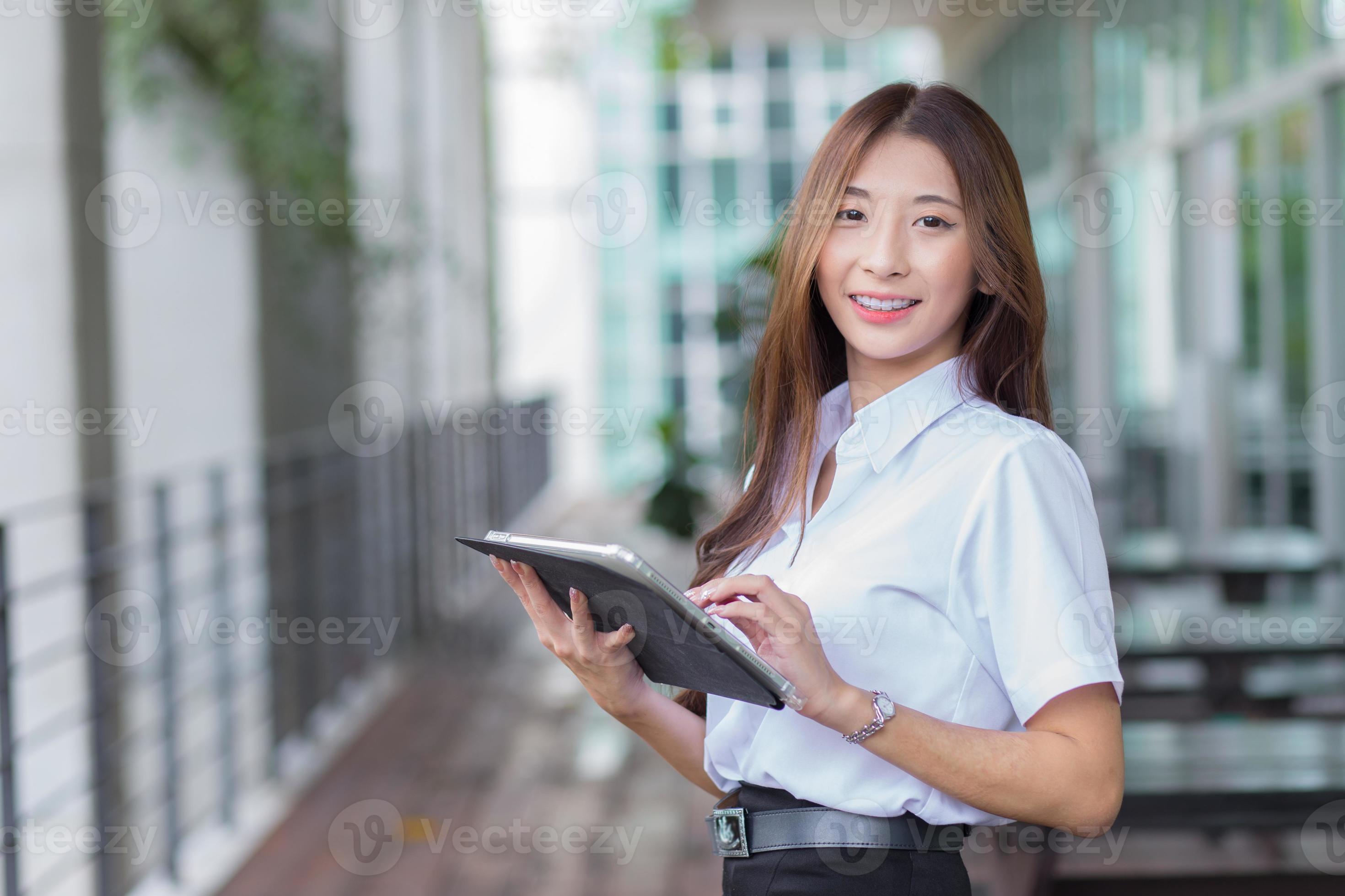 Portrait of cute Asian Thai girl student in a uniform is standing smiling happily and ...