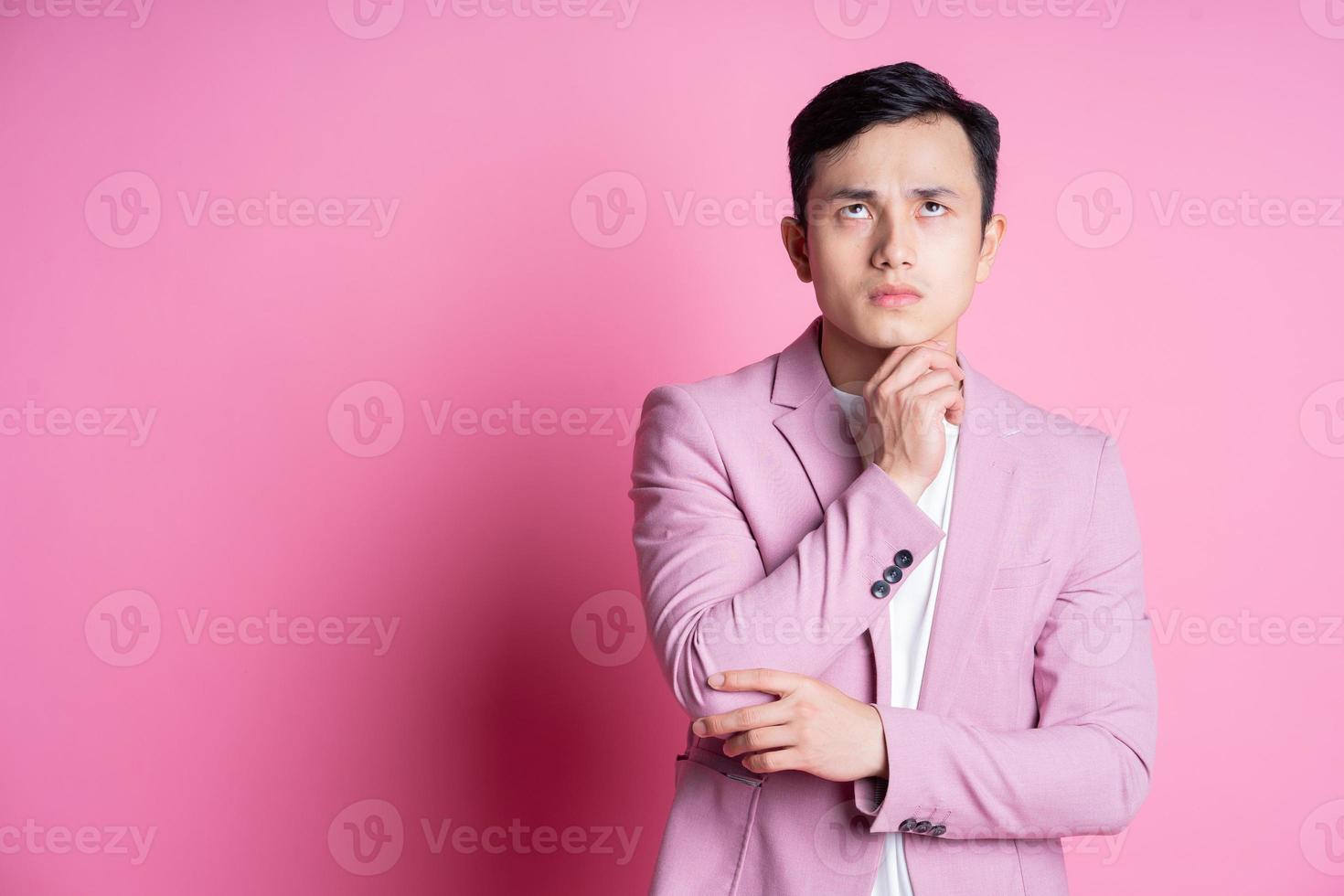 Portrait Of Young Asian Man Wearing Pink Suit Posing On Background