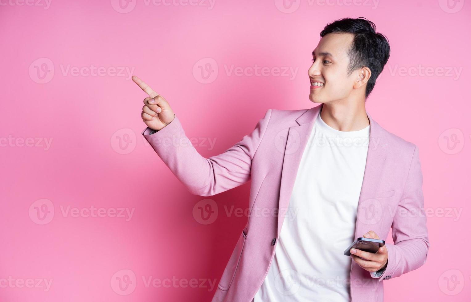 Portrait Of Young Asian Man Wearing Pink Suit Posing On Background