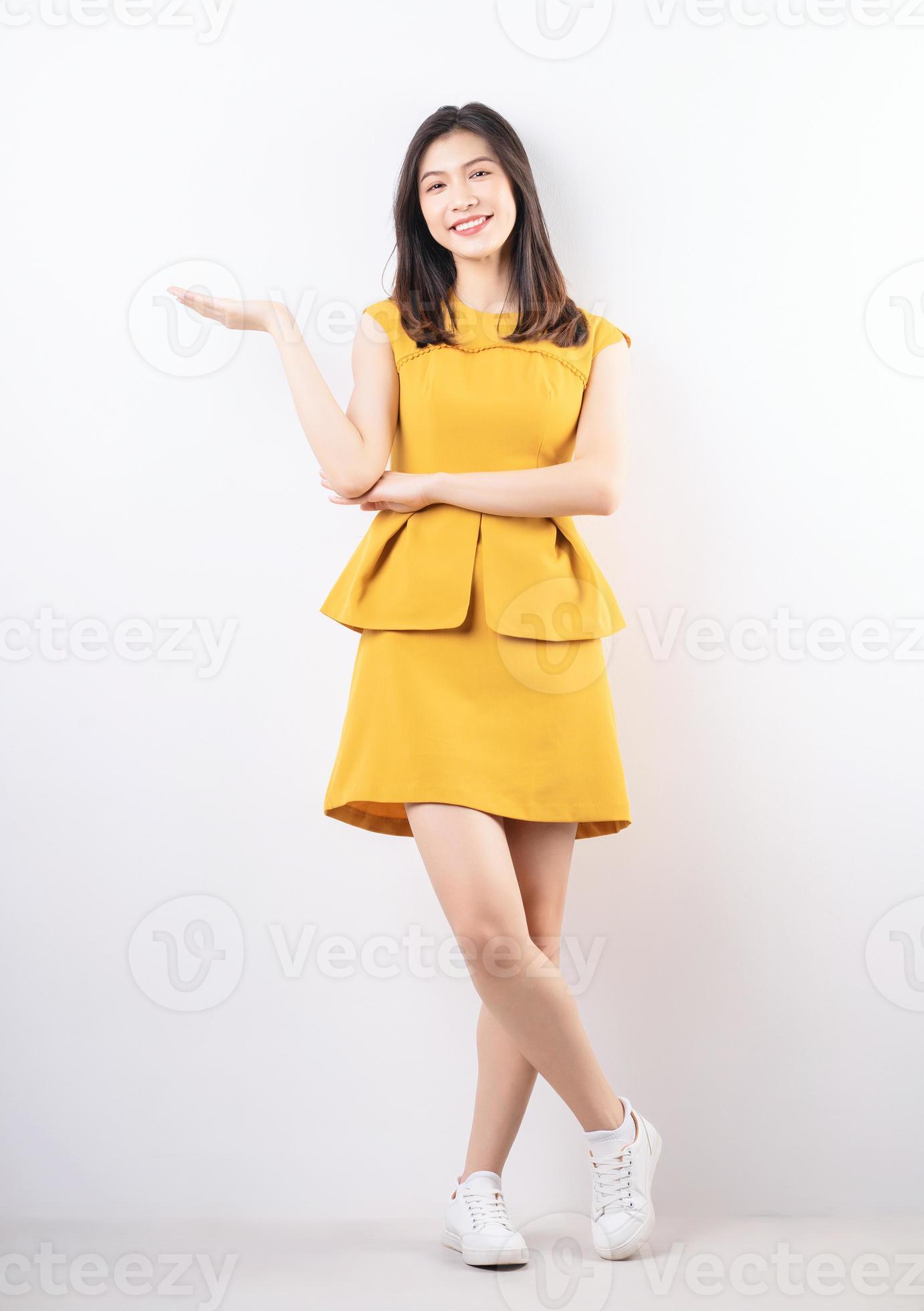 Full length photo of young Asian woman standing on white background ...