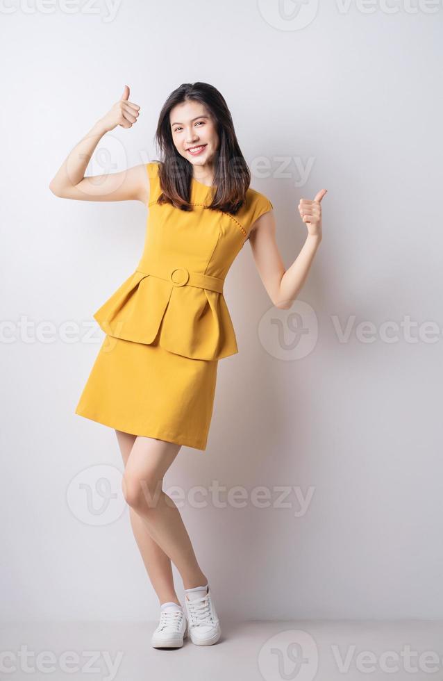 Full length photo of young Asian woman standing on white background ...