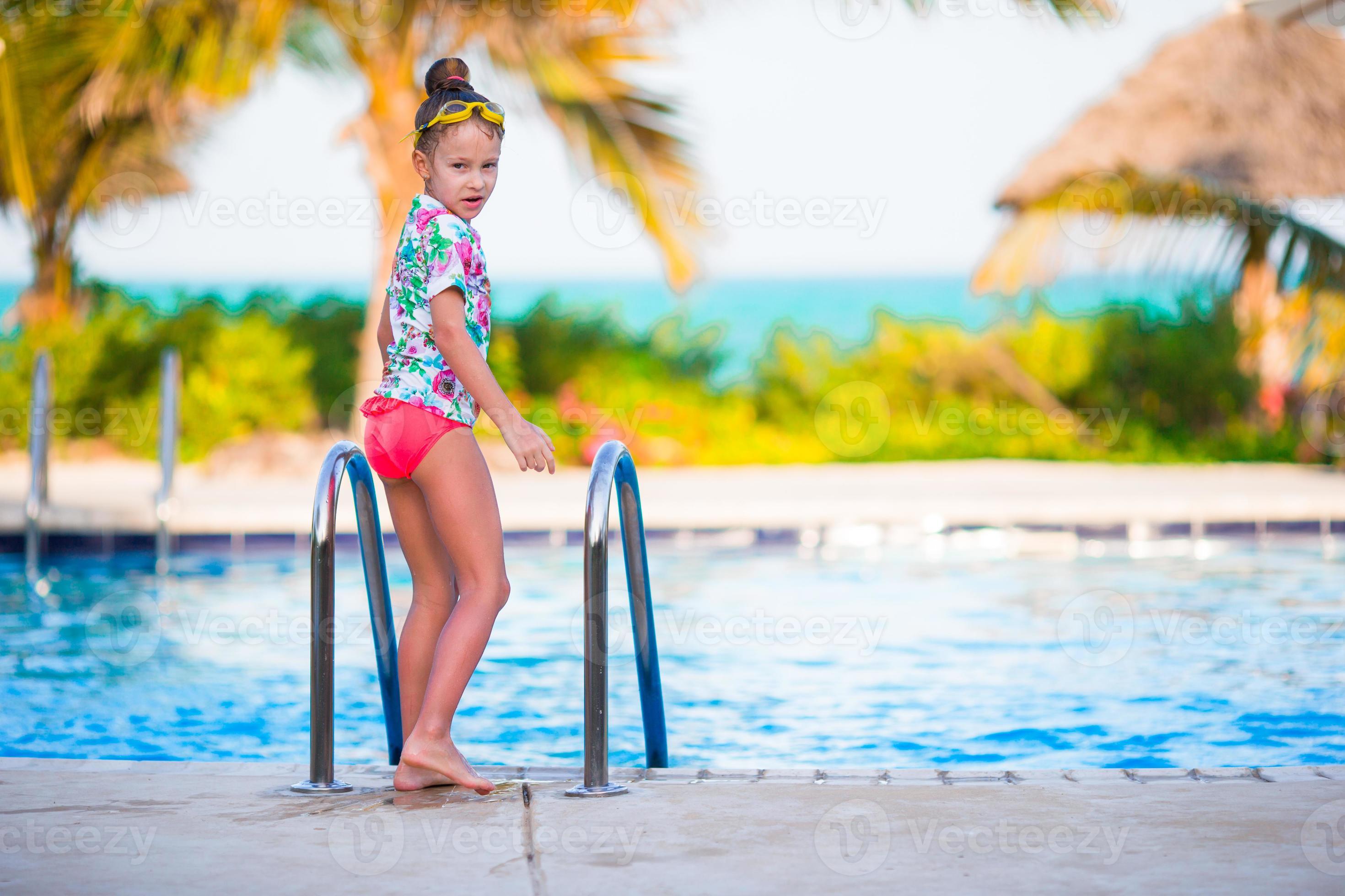 niña adorable feliz en la piscina al aire libre. hermosa adolescente disfruta nadando en la ...