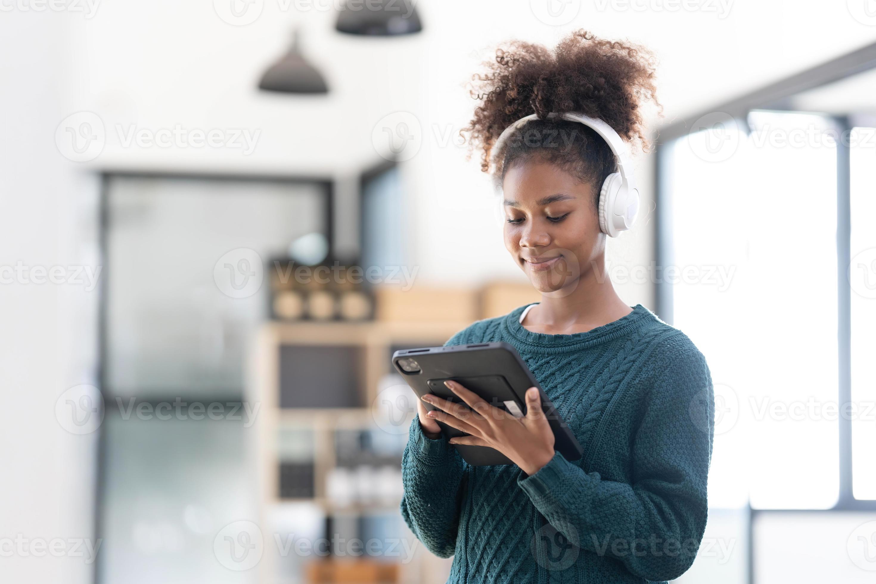 Portrait of smiling young black woman listening music with headset and ...