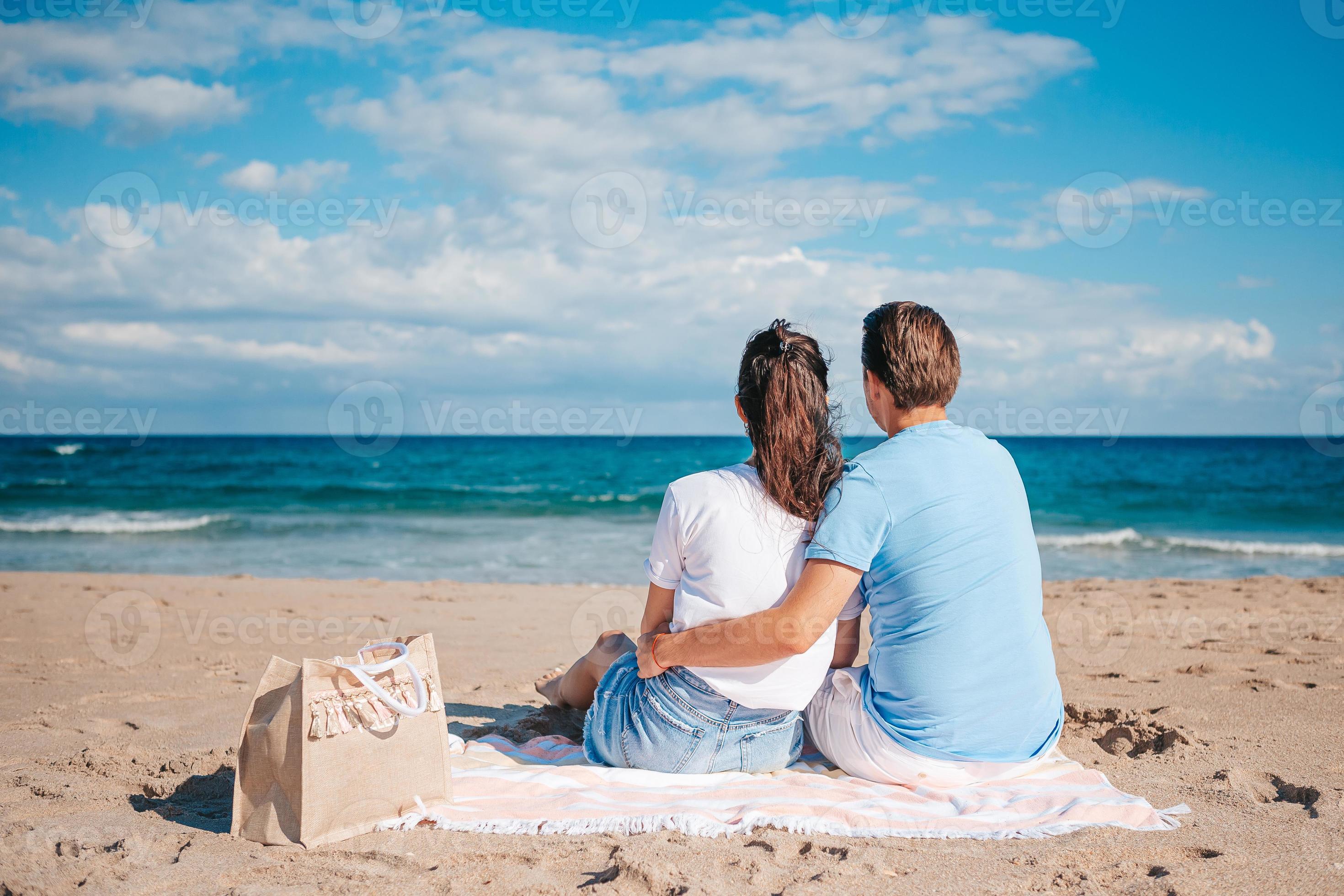 joven pareja de enamorados en las vacaciones de verano en la playa. hombre y mujer felices miran ...