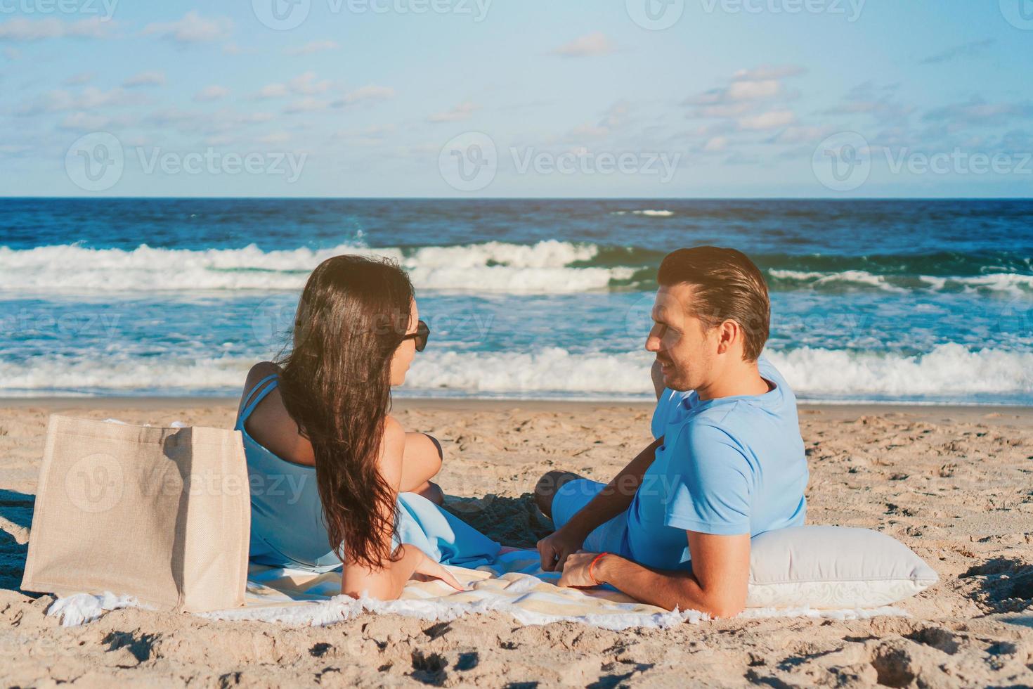 joven pareja de enamorados en las vacaciones de verano en la playa. hombre y mujer felices miran ...