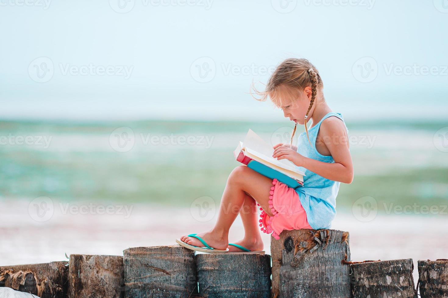Little adorable girl reading book during tropical white beach 18044323 ...