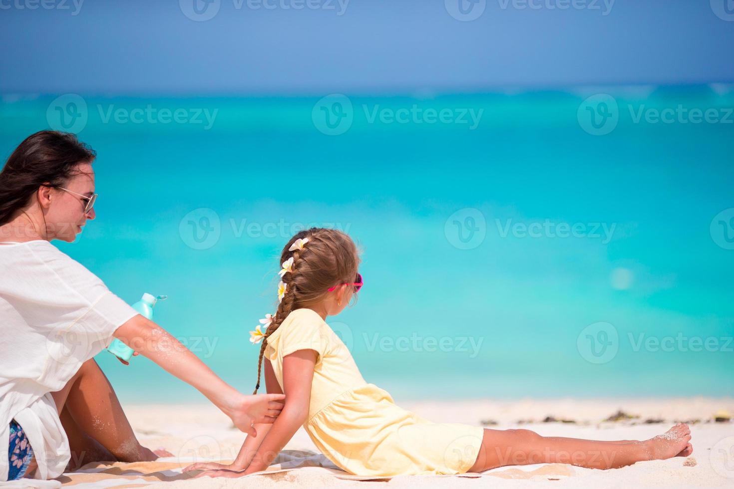 Mother Applying Sun Protection Cream To Her Daughter At Tropical Beach
