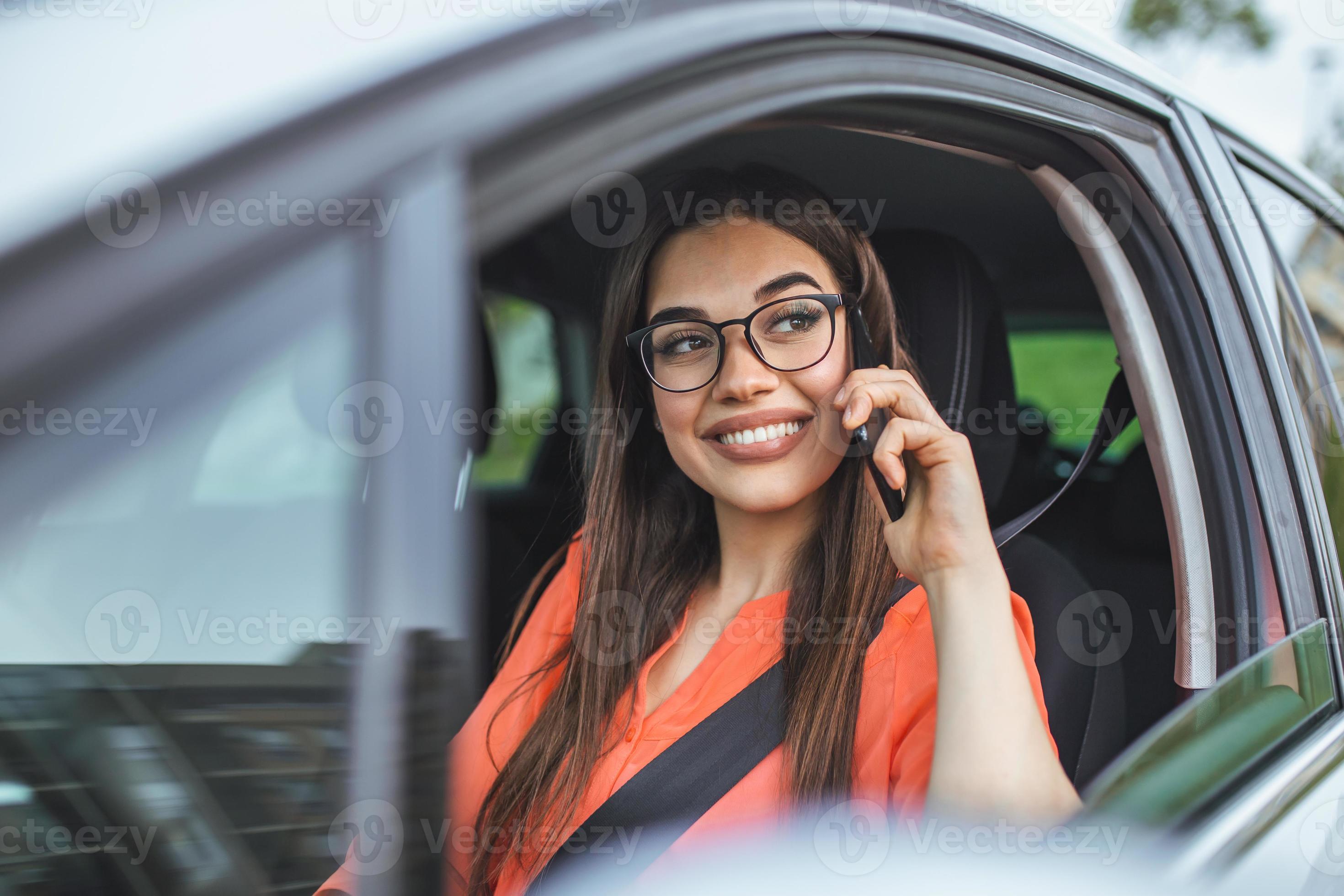 mujer de negocios conduciendo un coche y hablando por teléfono celular ...