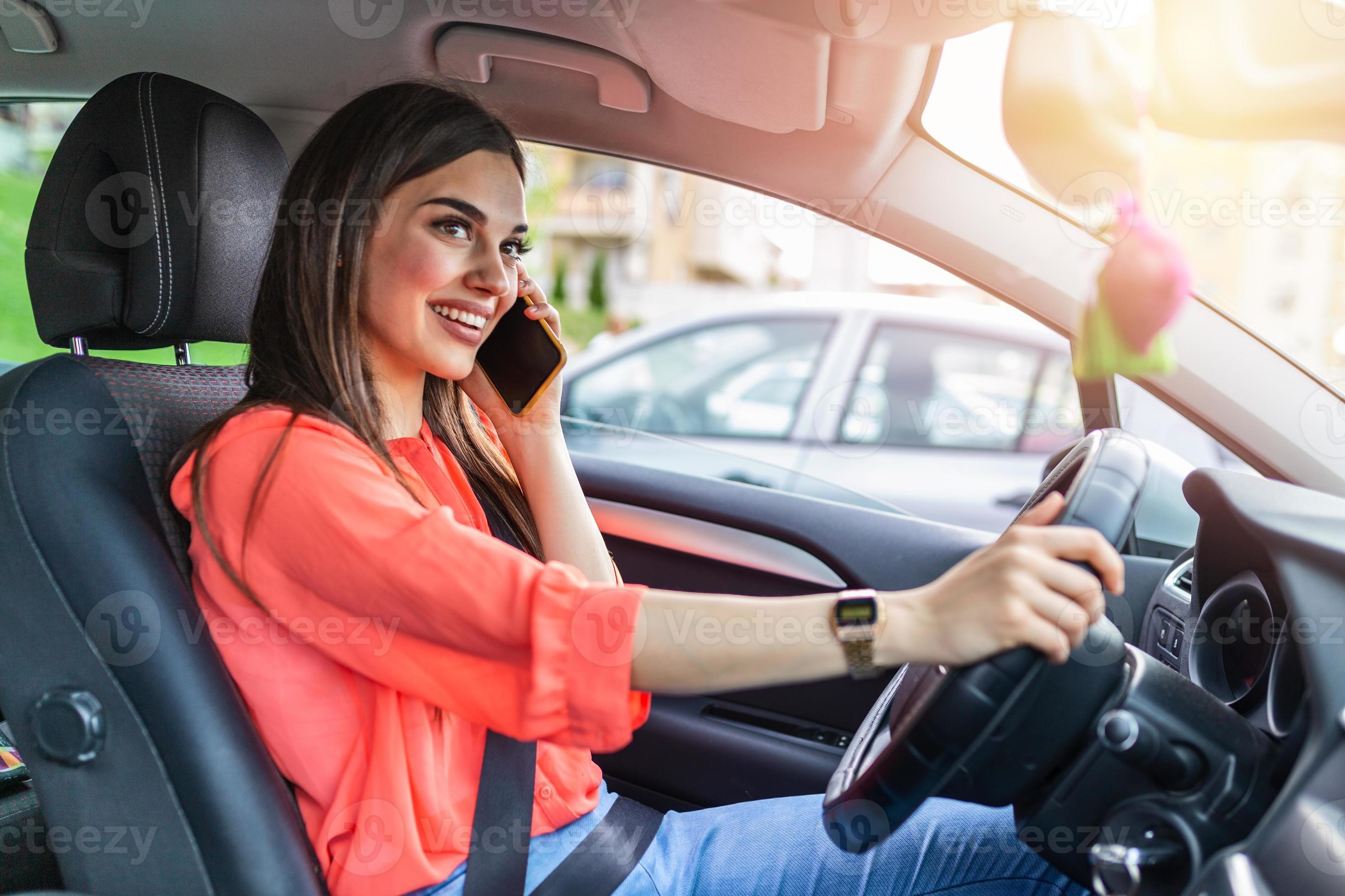 Businesswoman driving car and talking on cell phone concentrating on ...
