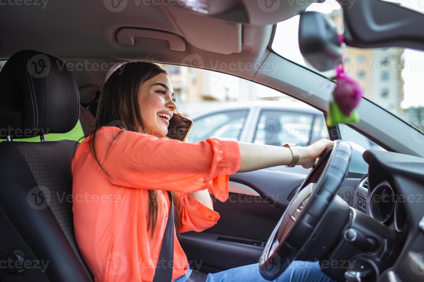 Businesswoman driving car and talking on cell phone concentrating on ...