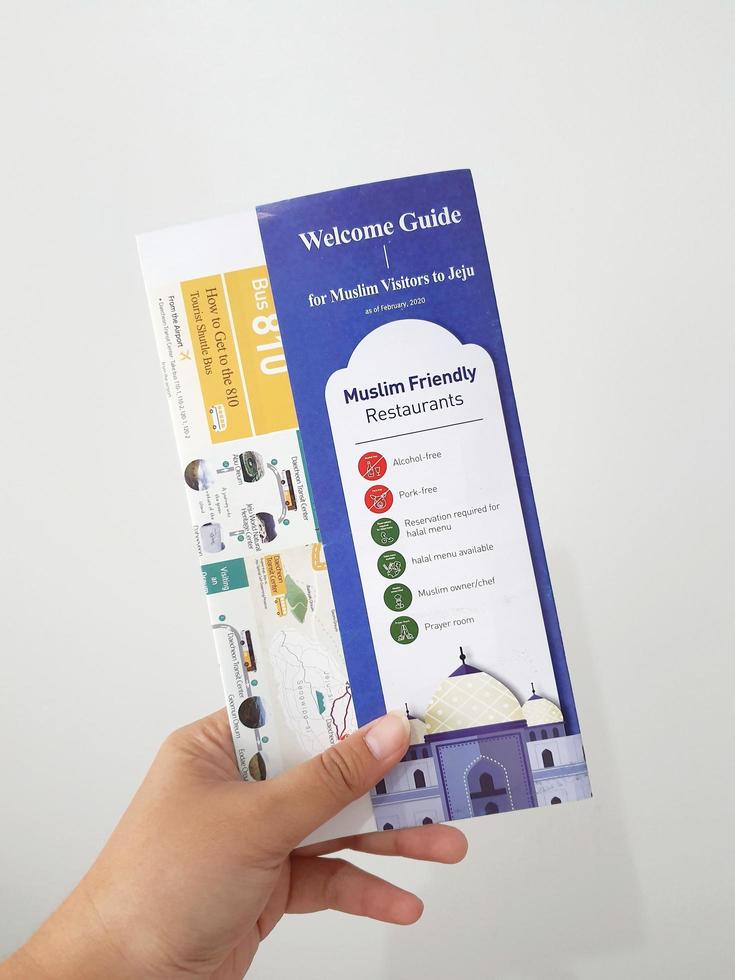 Jakarta, Indonesia in May 2022. A hand is holding a welcome guide book ...