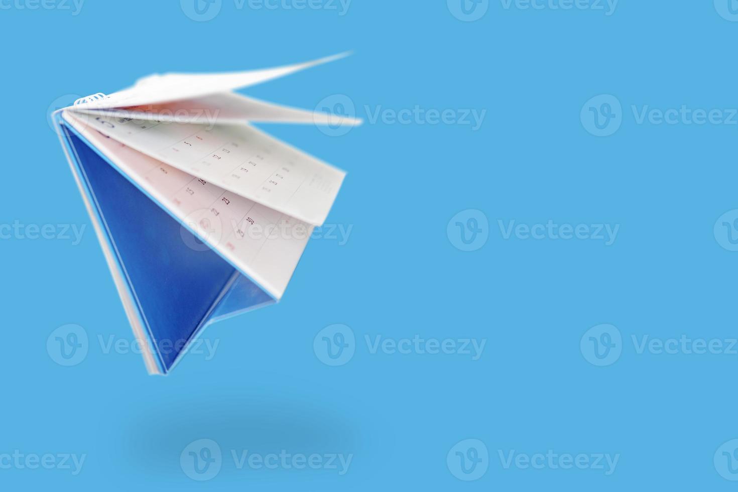 White paper desk calendar flipping page isolated on blue background ...