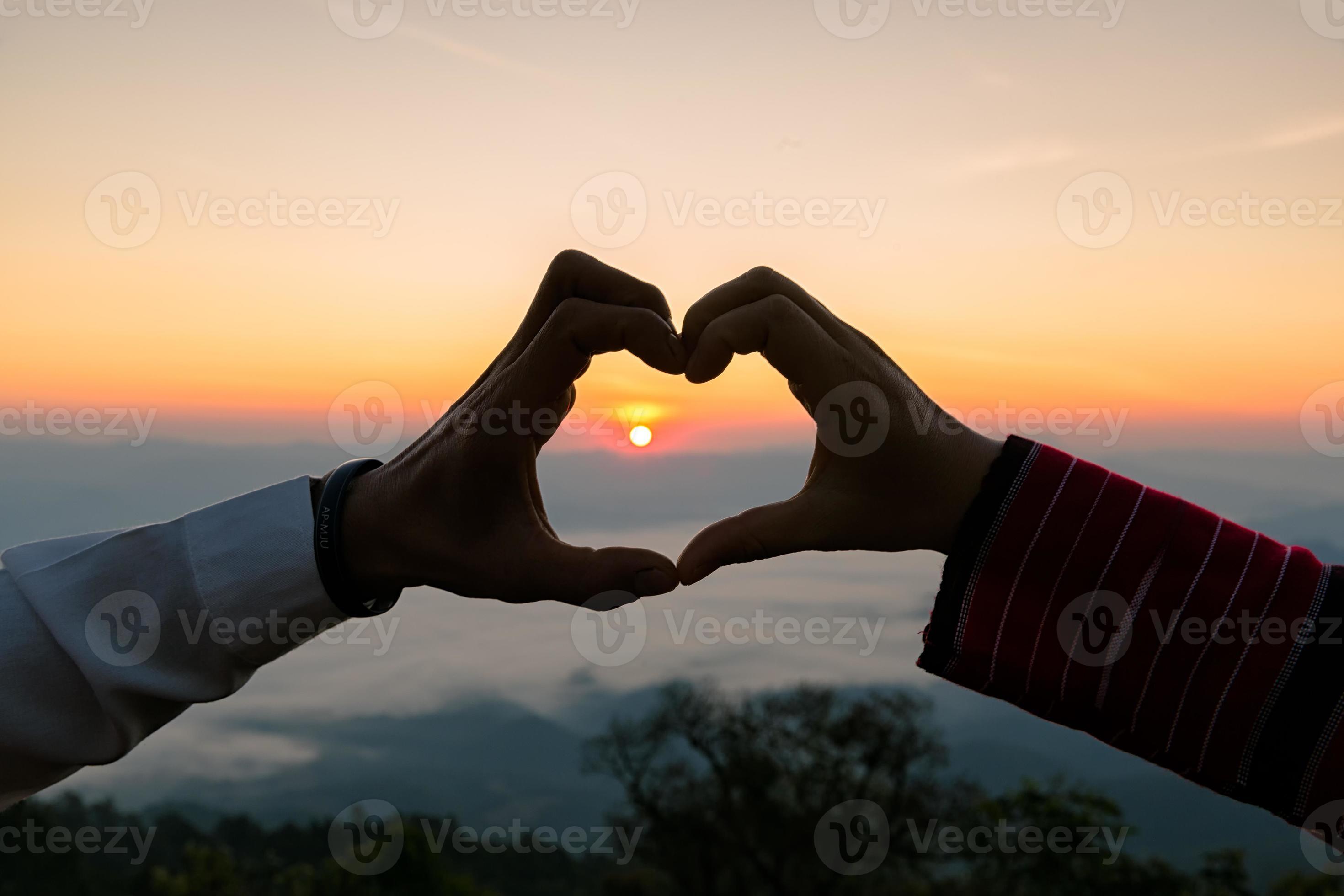 Silhouette of wedding Couple in love hand sign heart during sunrise with morning sky background ...