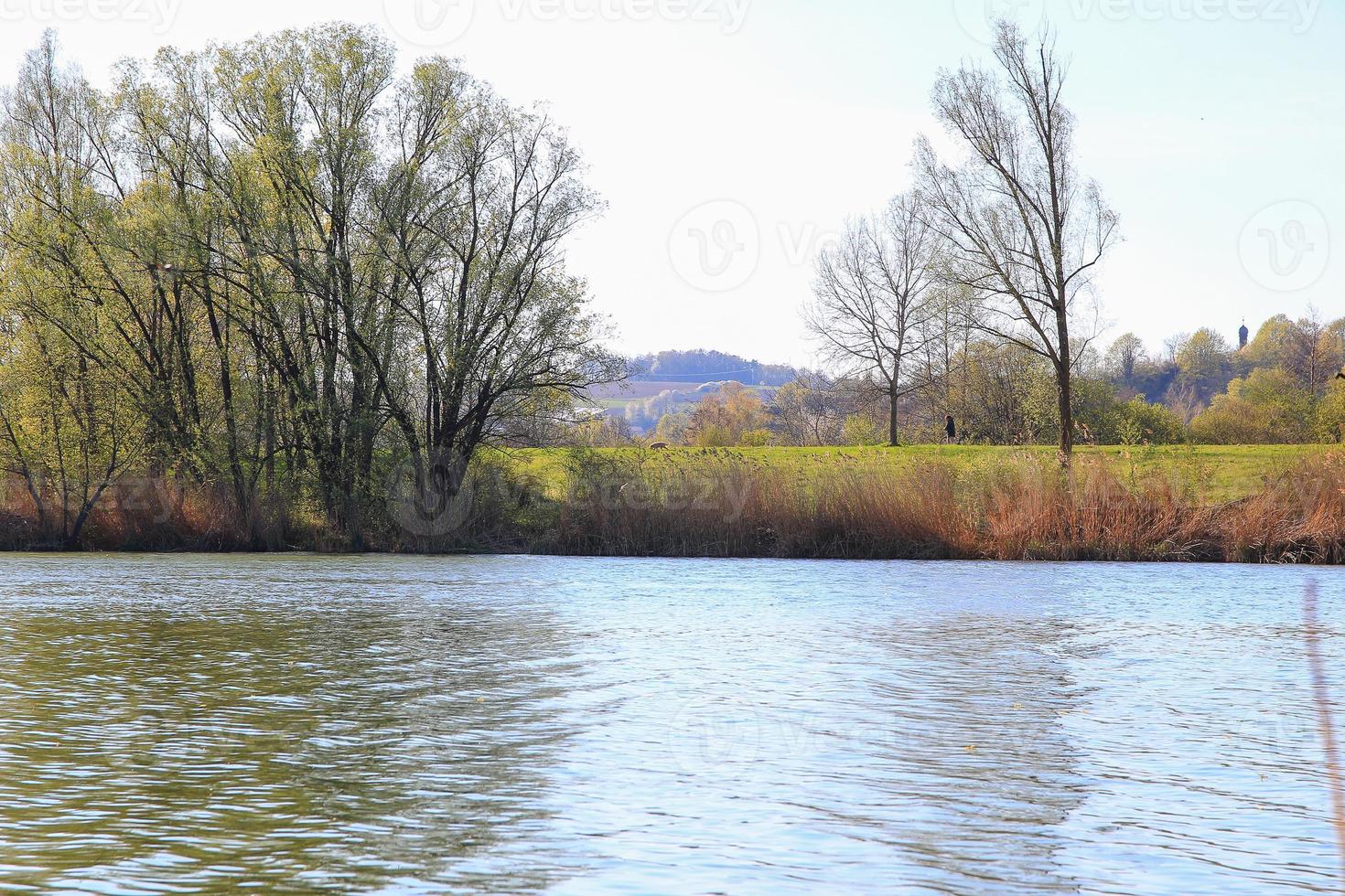 people are riding the bike on a rural road at sunset along Danube river in Regensburg, Germany ...