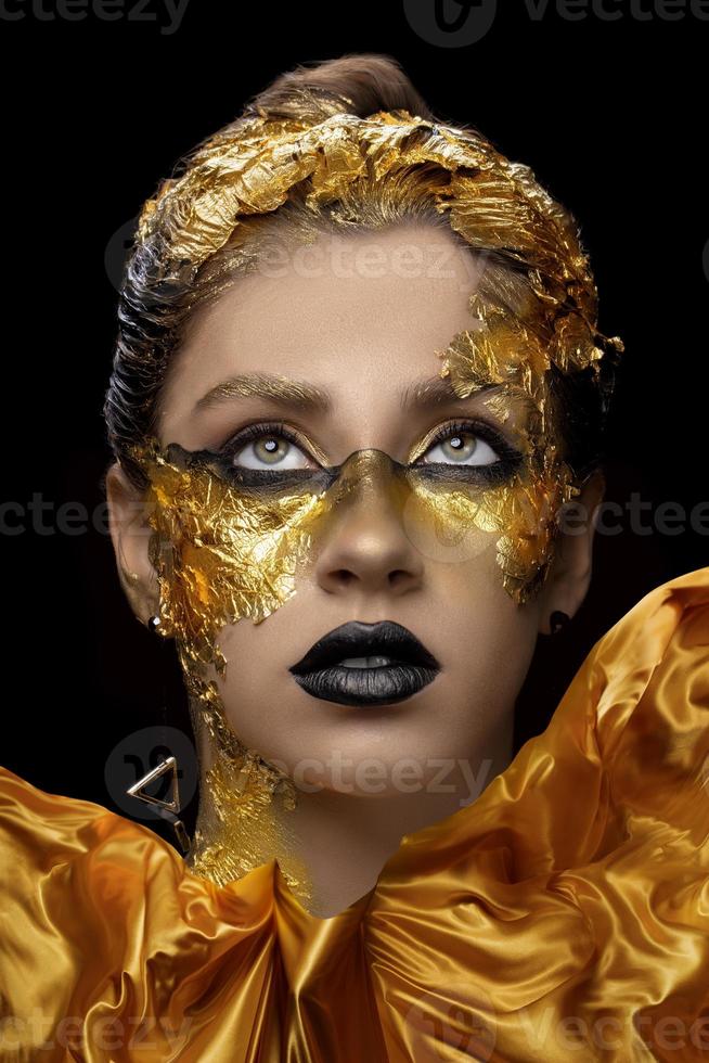 Fashion art Golden skin. Model girl with festive golden glamorous shiny professional make-up ...