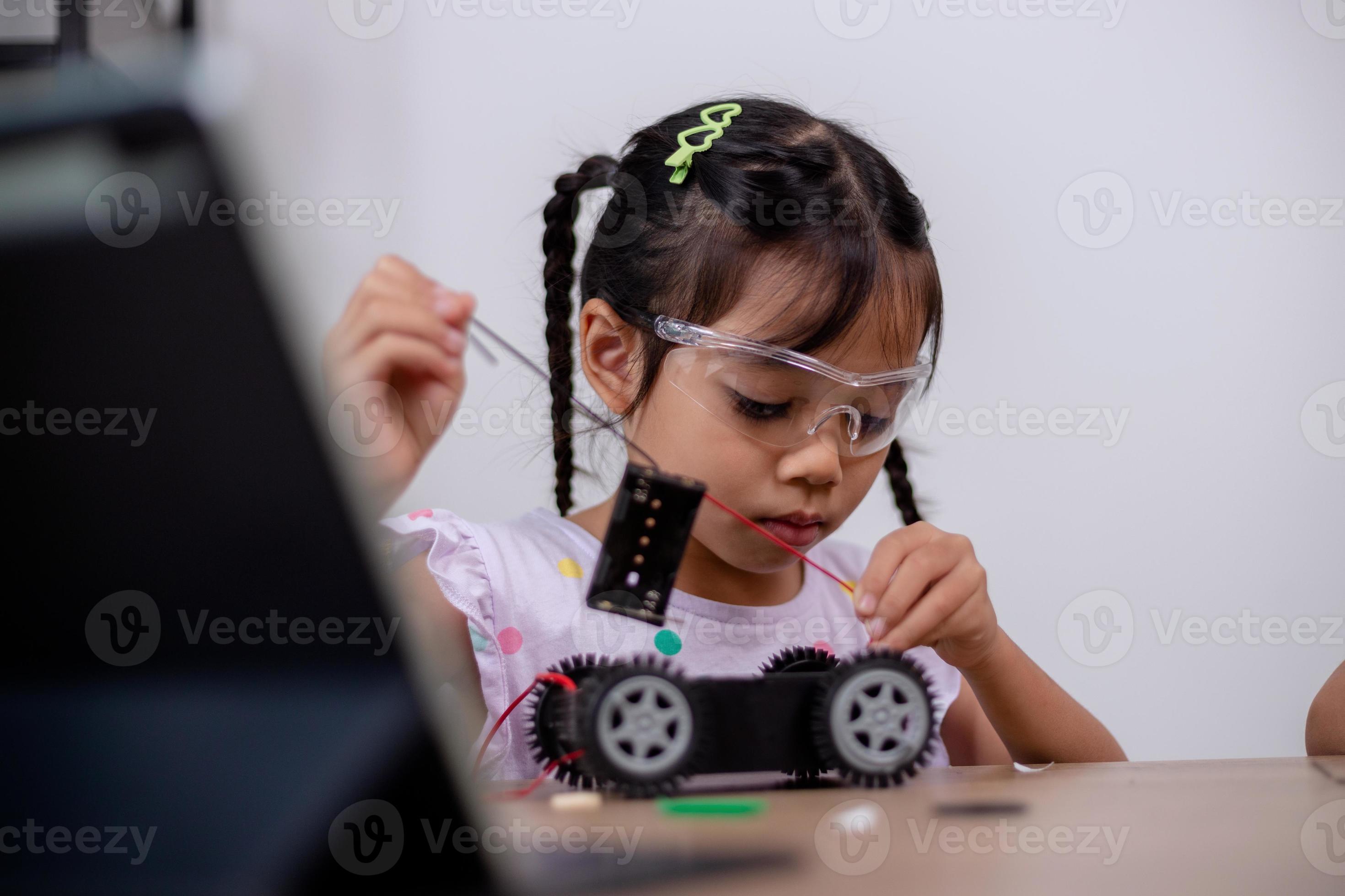 Asian students learn at home by coding robot cars and electronic board ...