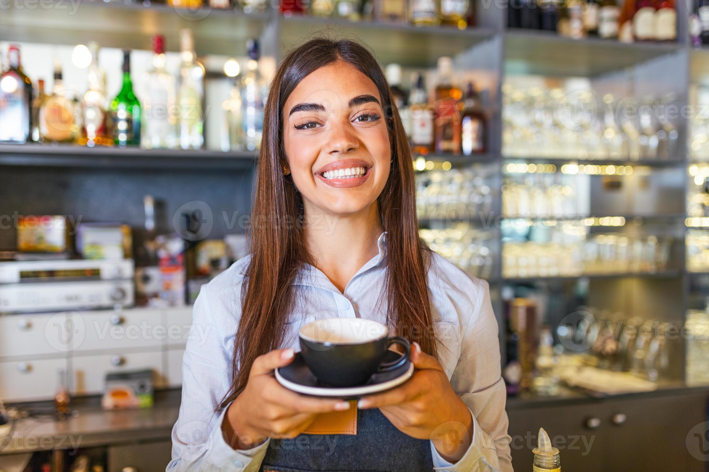 Beautiful Female Barista Is Holding A Cup With Hot Coffee Looking At