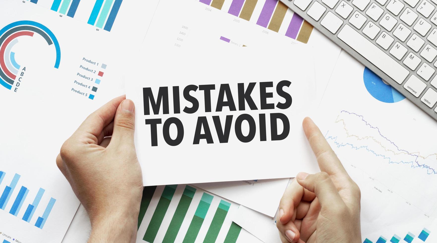 Hand Holding Paper With Text Mistakes To Avoid With Charts And Keyboard