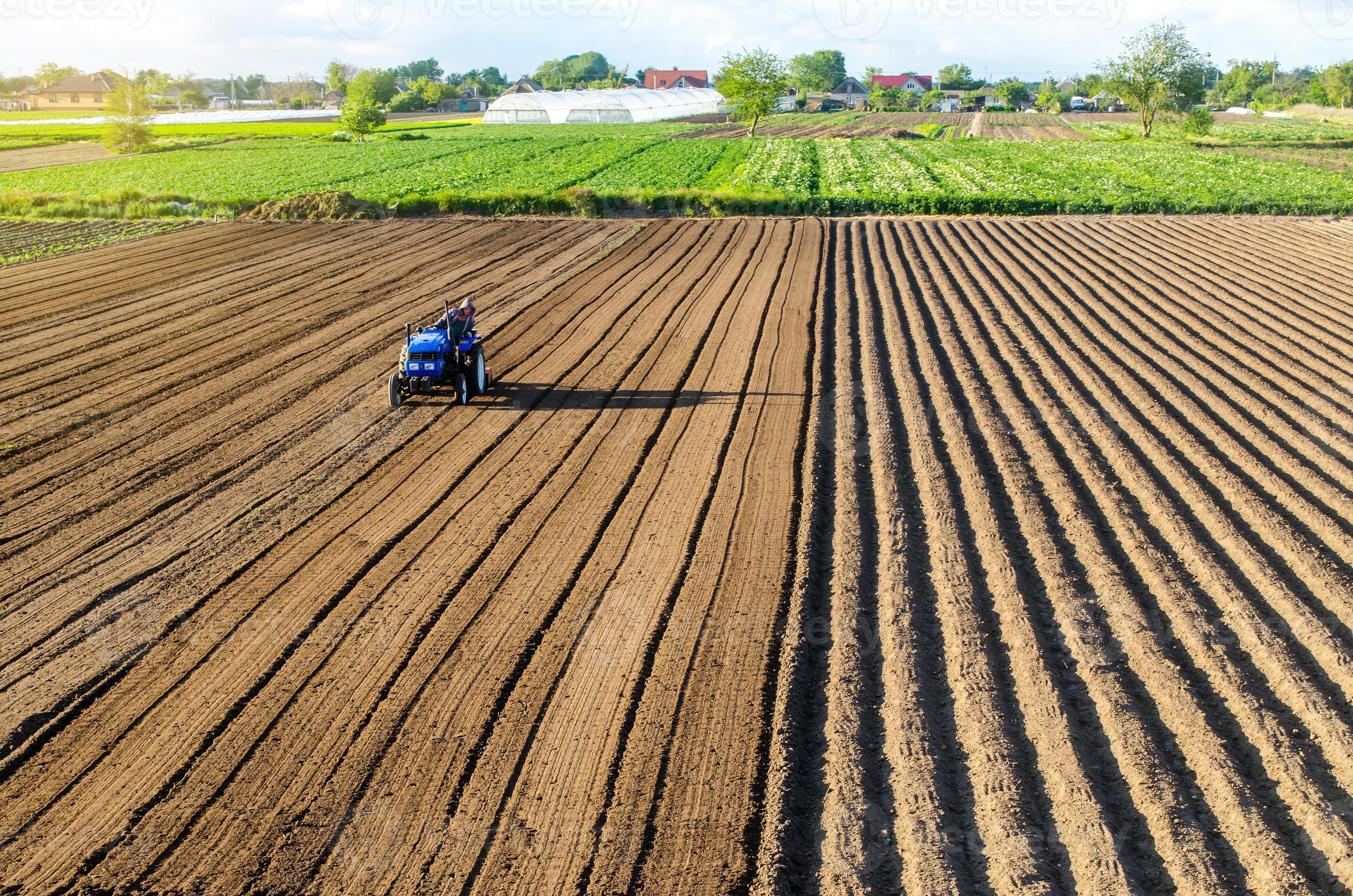 Tractor on farmland field. Farm work. Milling soil, Softening the soil before planting new crops ...