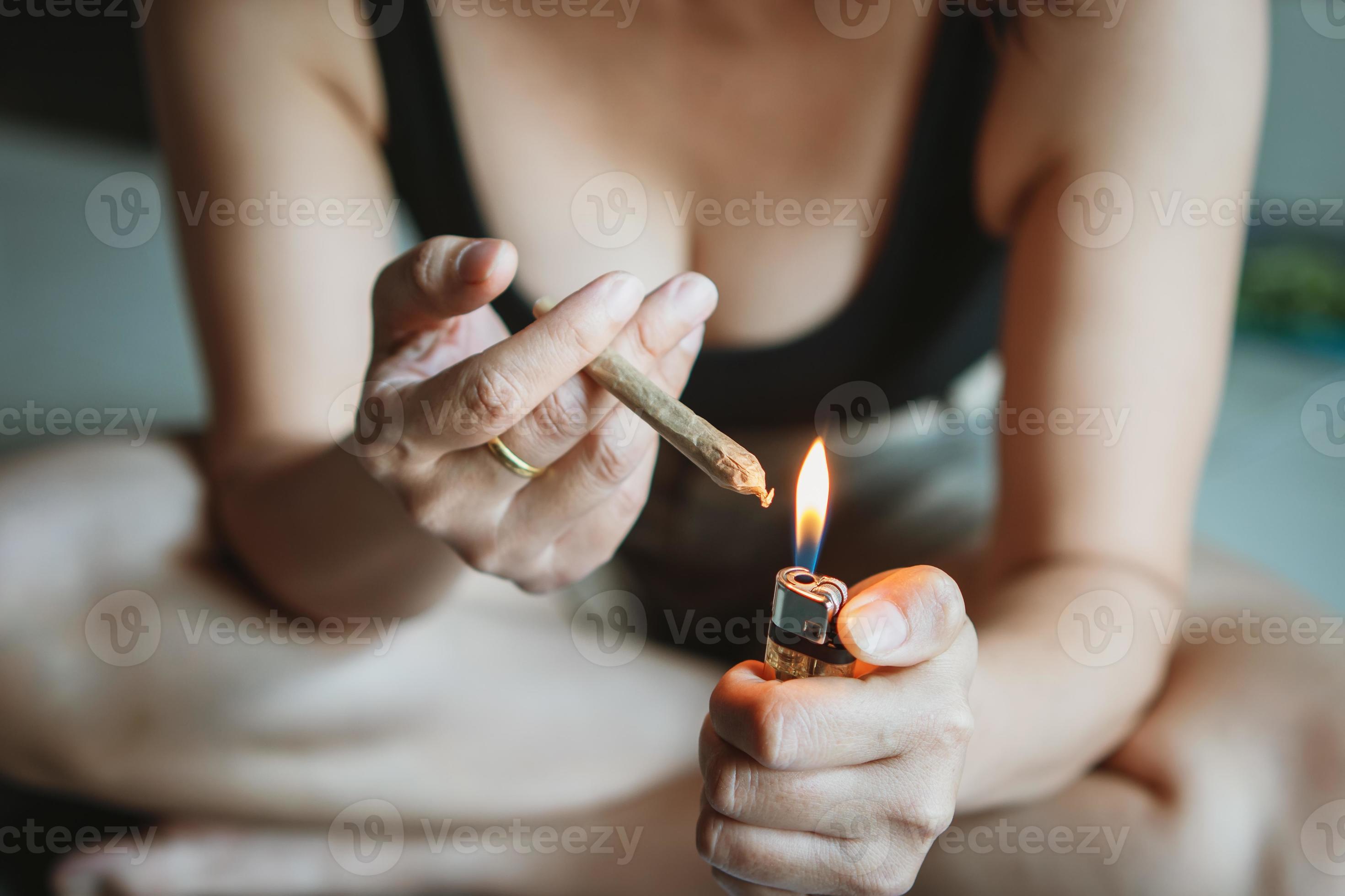 mujer preparando Encendiendo arriba marijuana articulación con encendedor. canabis fumador ...