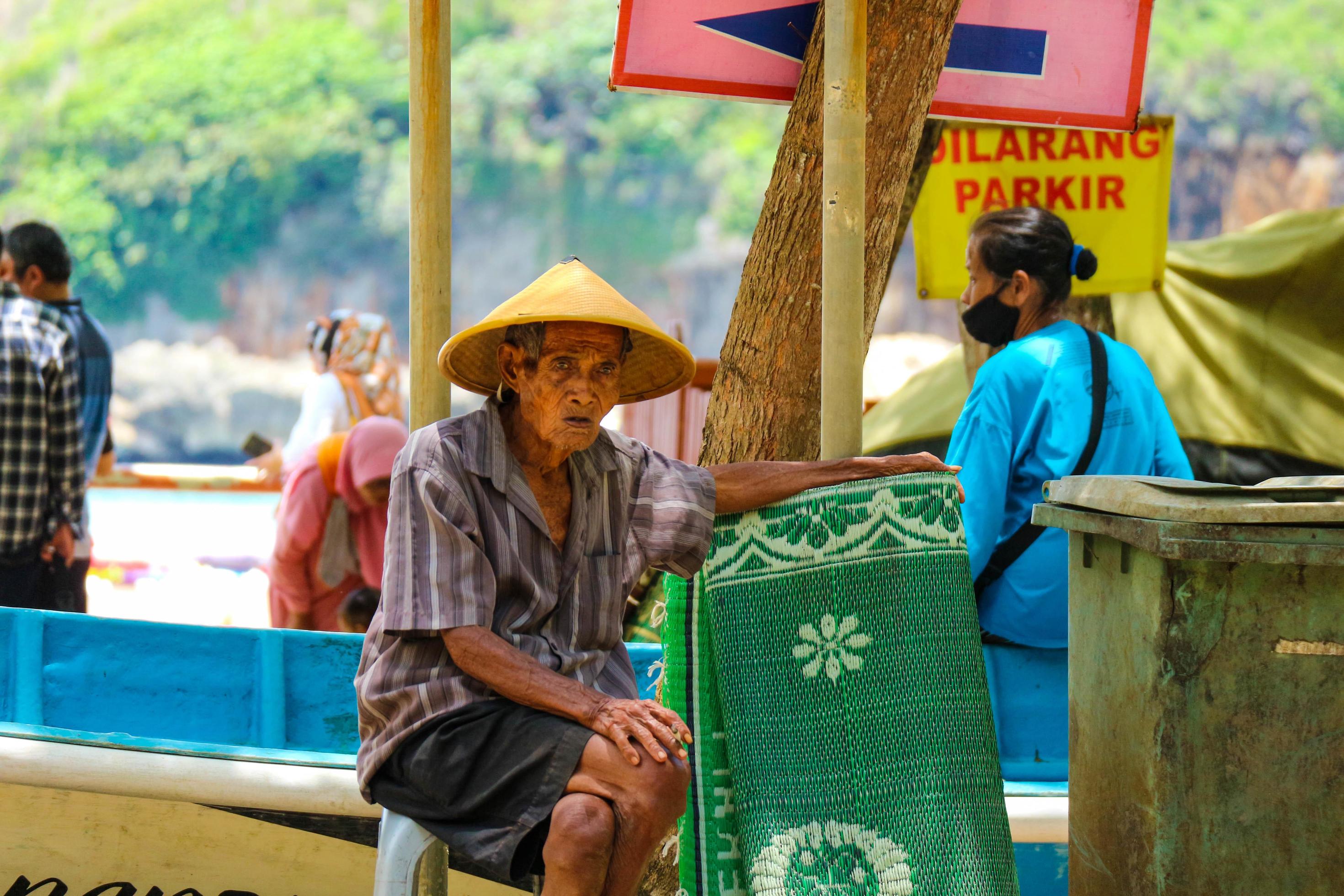 Yogyakarta, Indonesia in November 2022. Photo of a grandfather or old man renting mats at Baron ...
