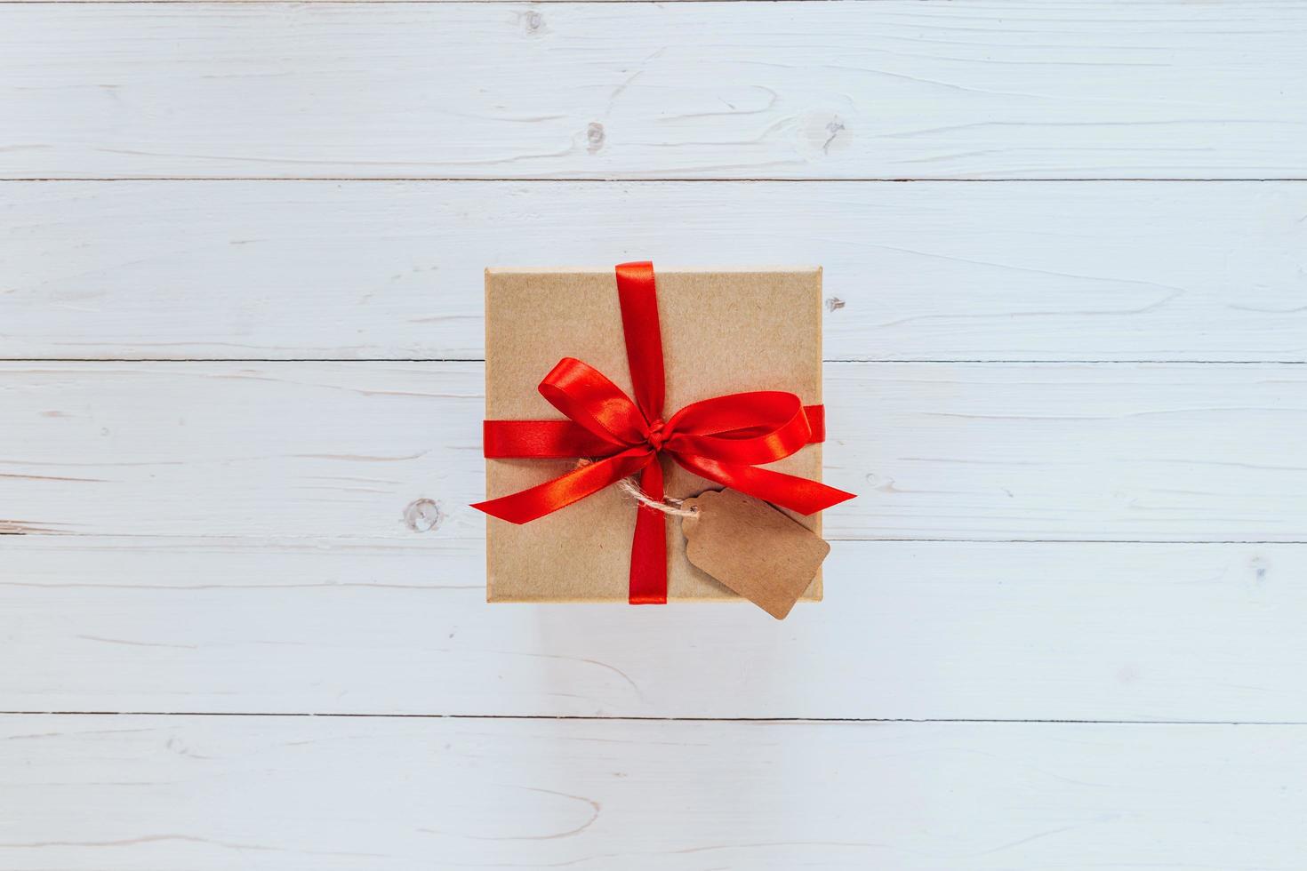Above Brown Gift Box With Tag On Wooden Board Background Gift Box With above-brown-gift-box-with-tag-on-wooden-board-background-gift-box-with