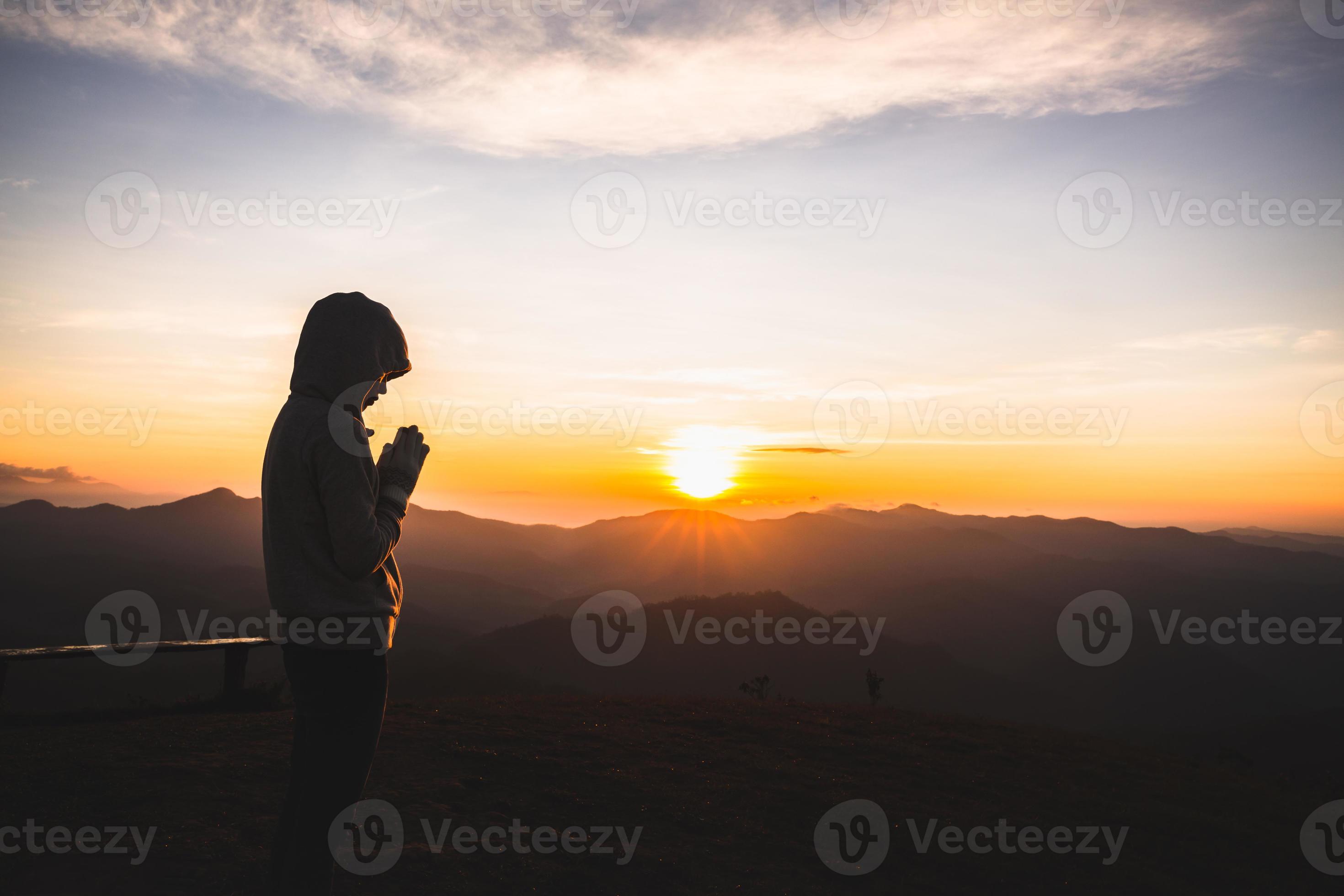 woman Praying hands with faith in religion and belief in God On the morning sunrise background ...