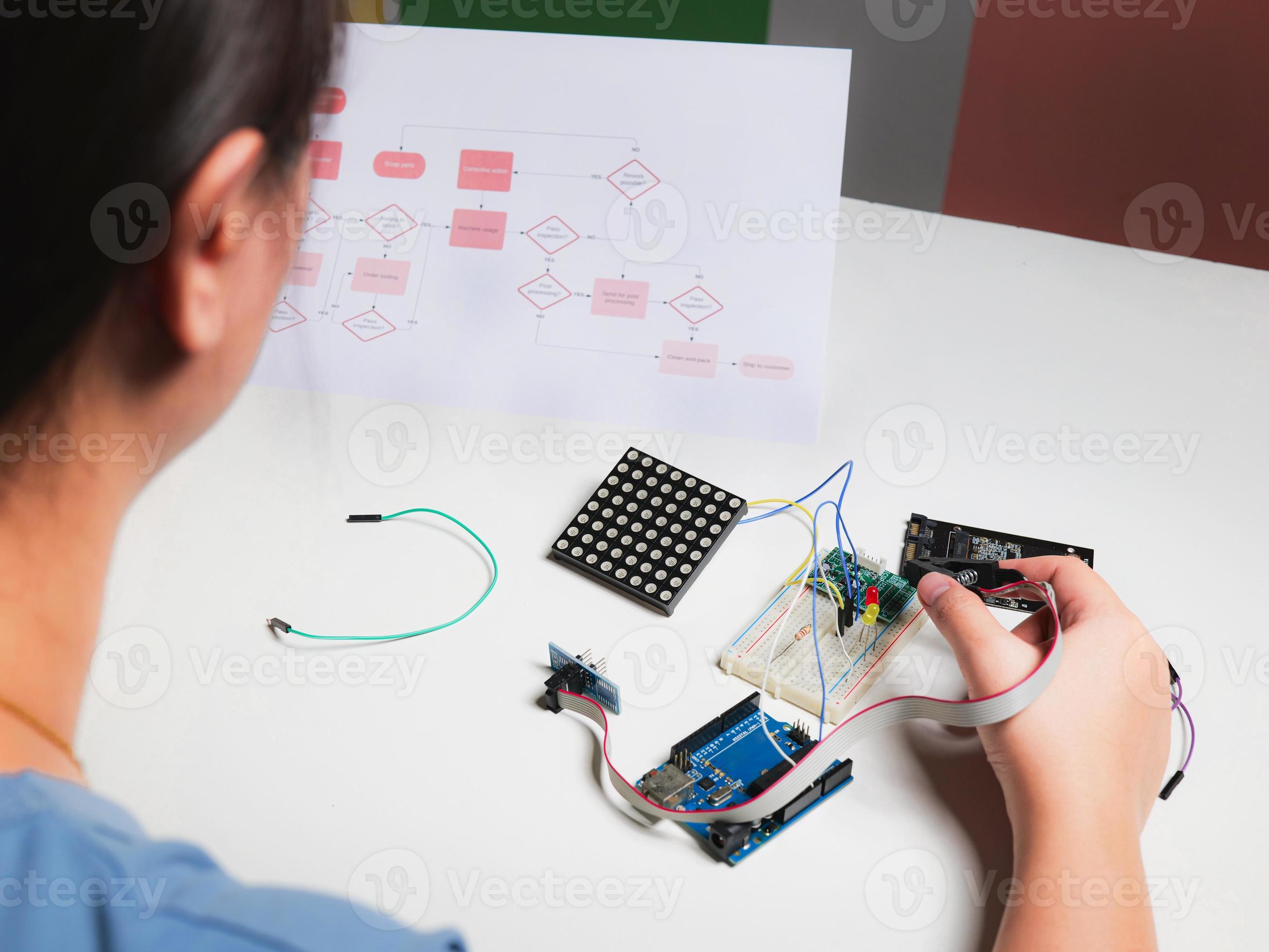 Back view young asian woman sitting at table using onboard programming ...