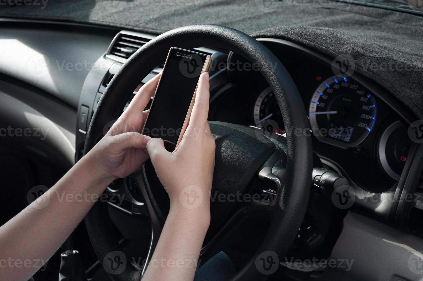 Woman using a smartphone while driving a car between driving because ...