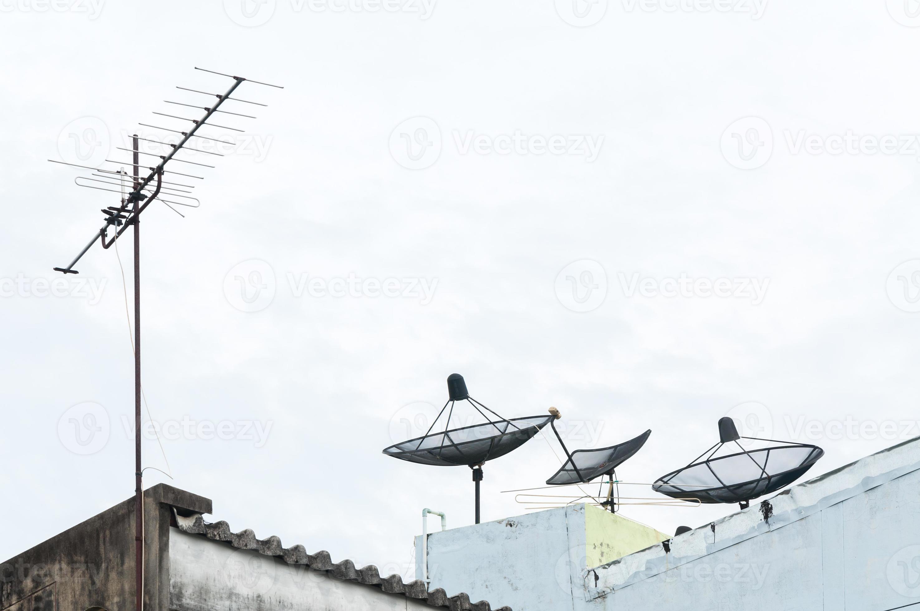 Satellite dish and television antenna on the old building with the blue ...