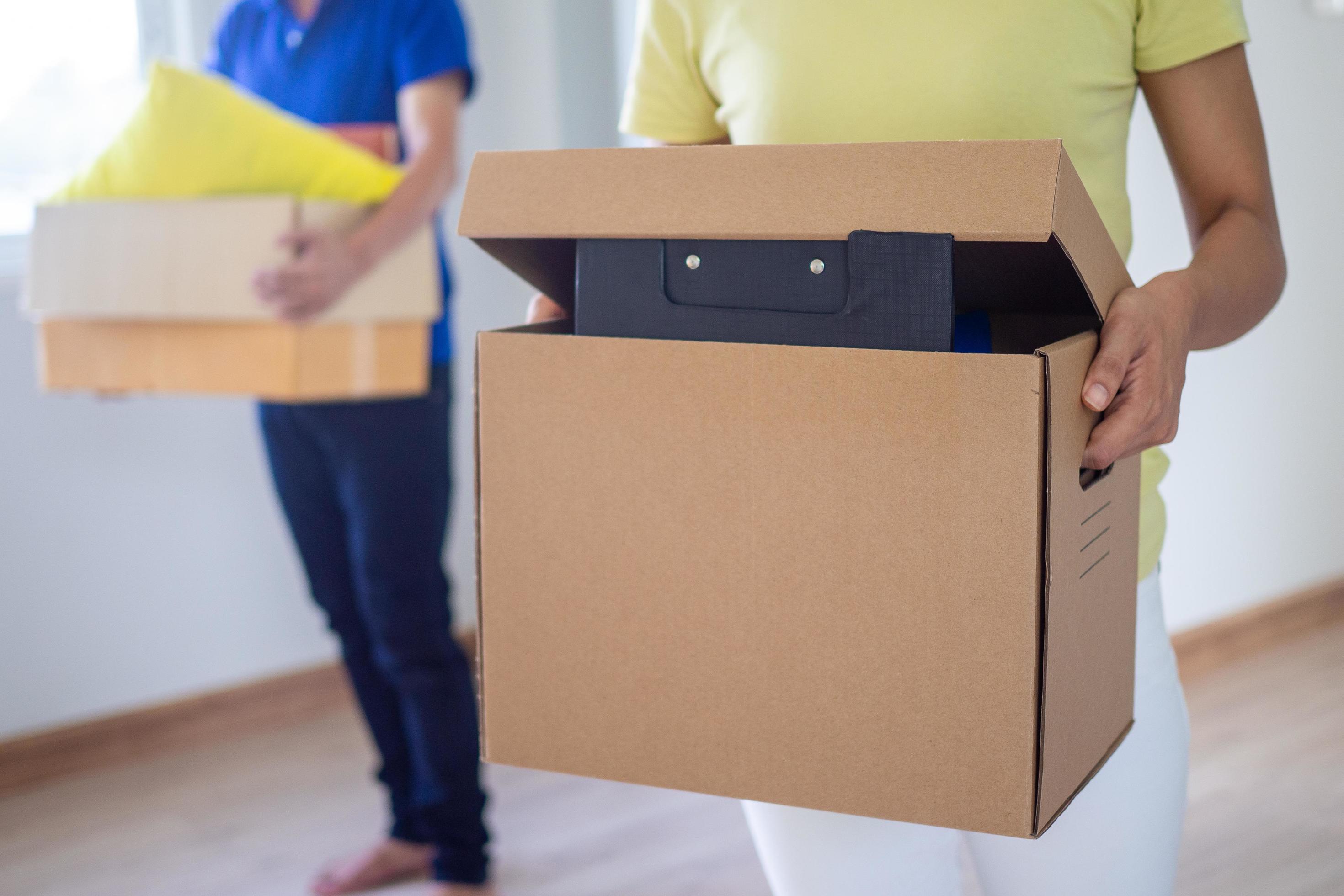 Couples helped each other move the brown box into the new house ...